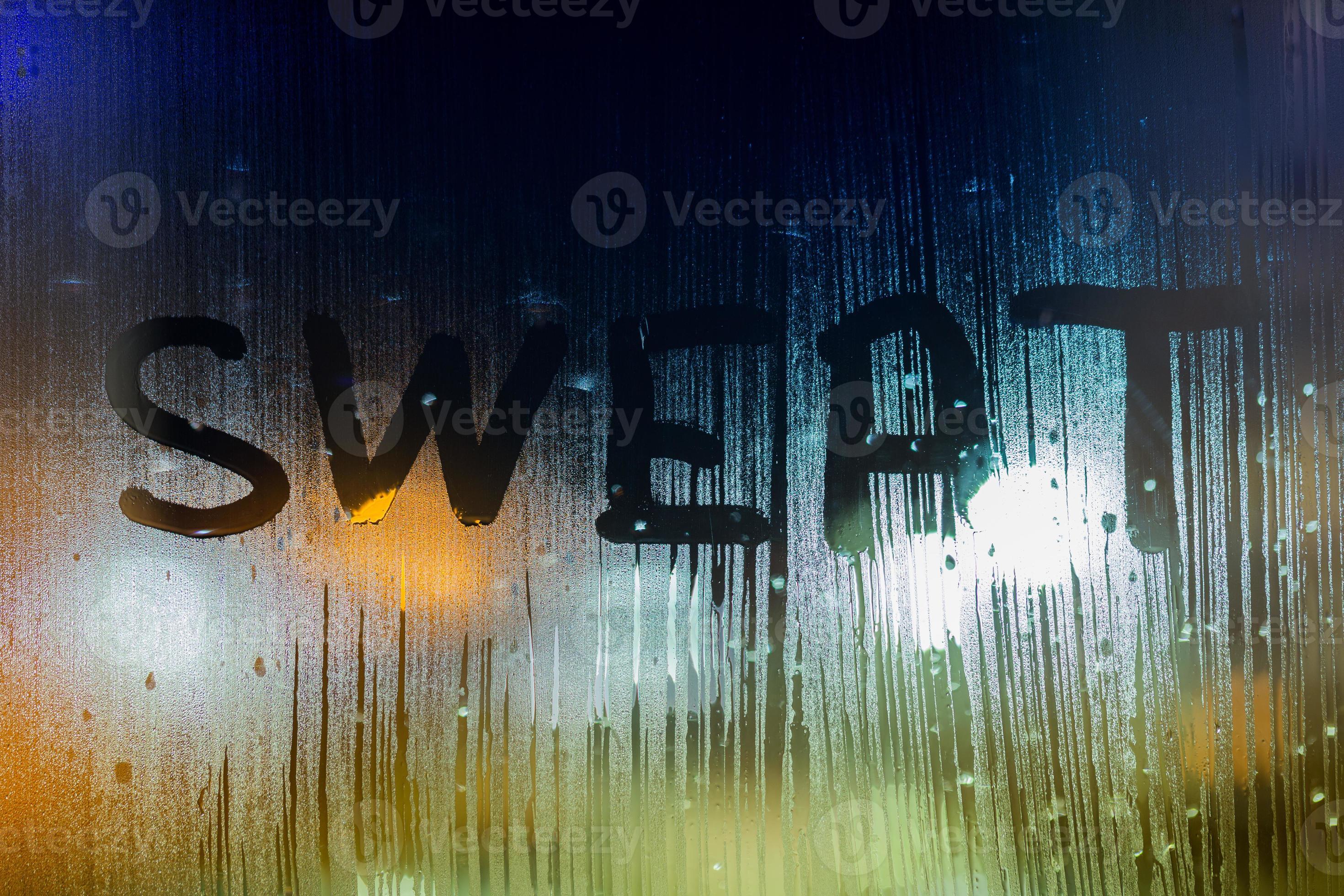 The Word Sweat Written On Night Wet Window Glass Close Up With Bokeh