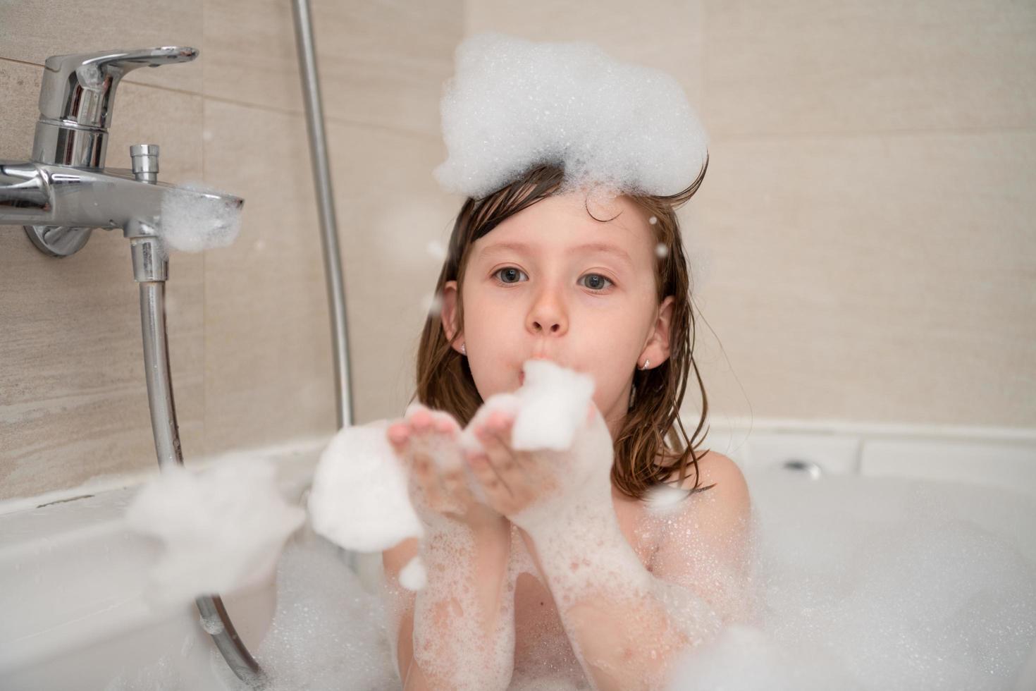 little girl in bath playing with foam 12645133 Stock Photo at Vecteezy