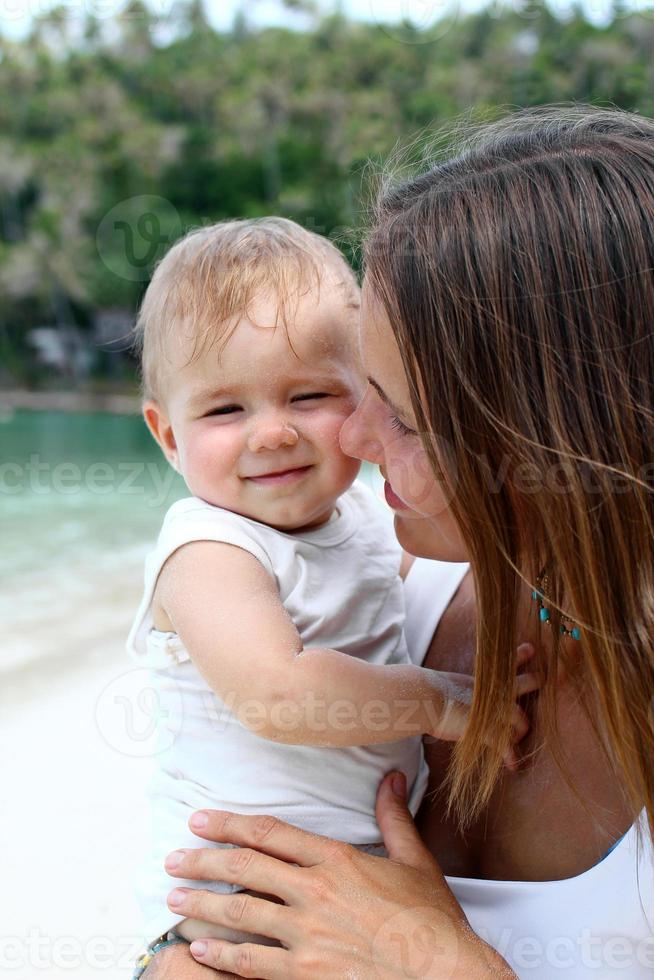 Portrait of beautiful young European mother hugging her little daughter on a background of ...