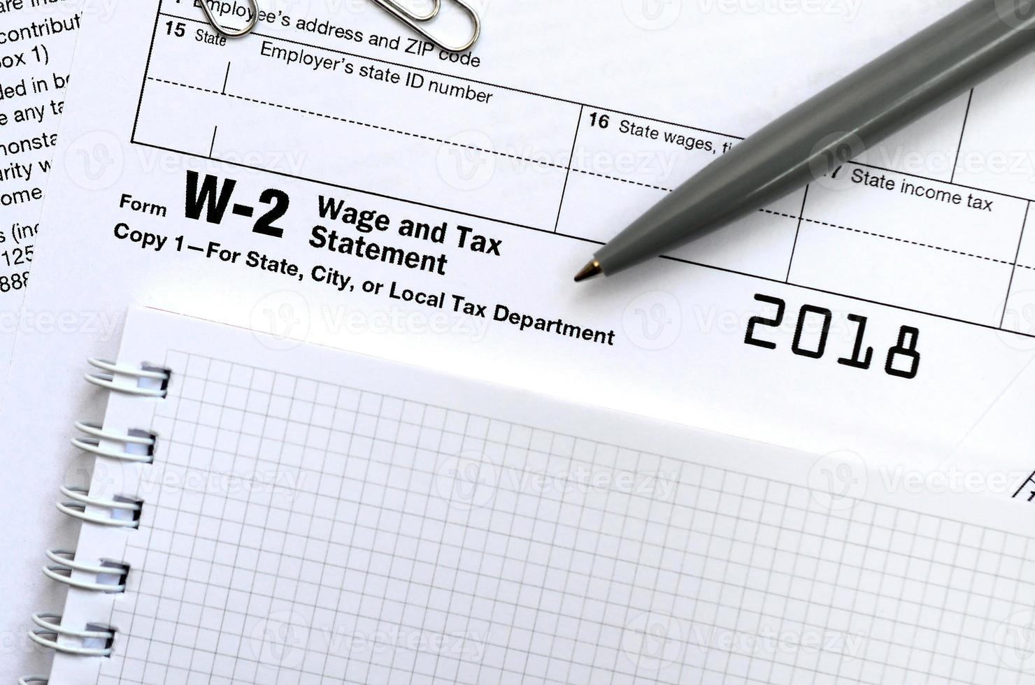 The pen and notebook on the tax form W-2 Wage and Tax Statement. The time to pay taxes 12752270 ...
