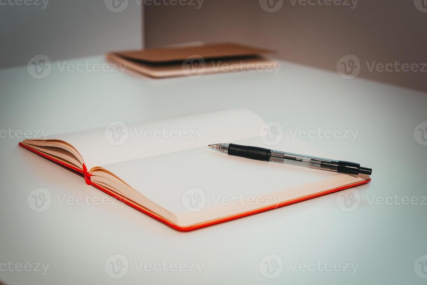 photo from a small angle of a black pen lying on a red open diary on the table 12784346 Stock ...