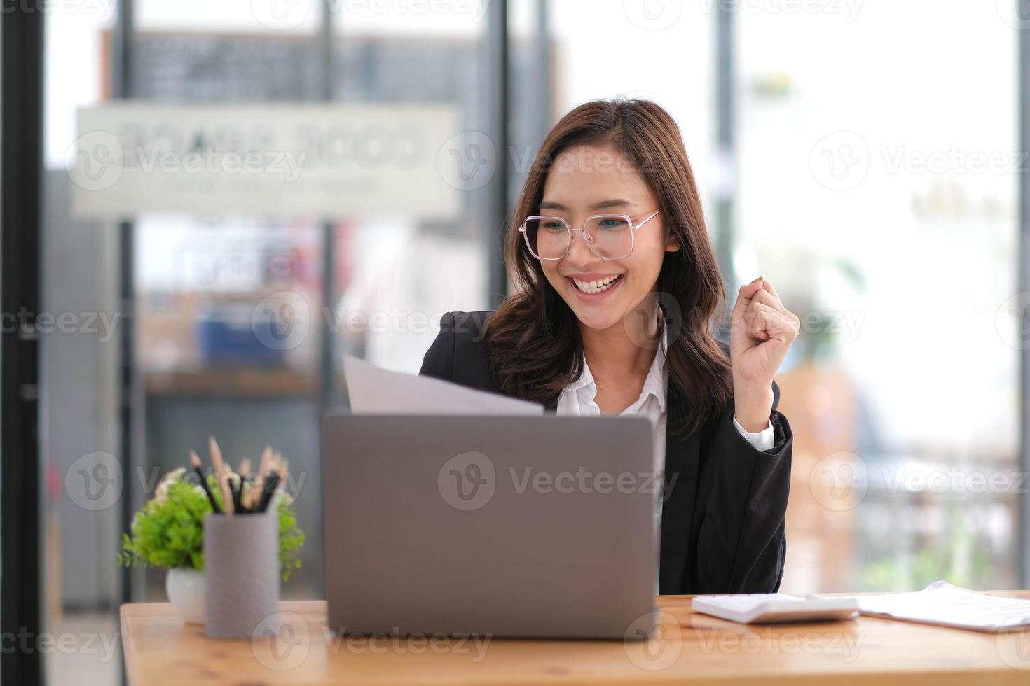 Happy excited successful Asian businesswoman triumphing with a laptop ...