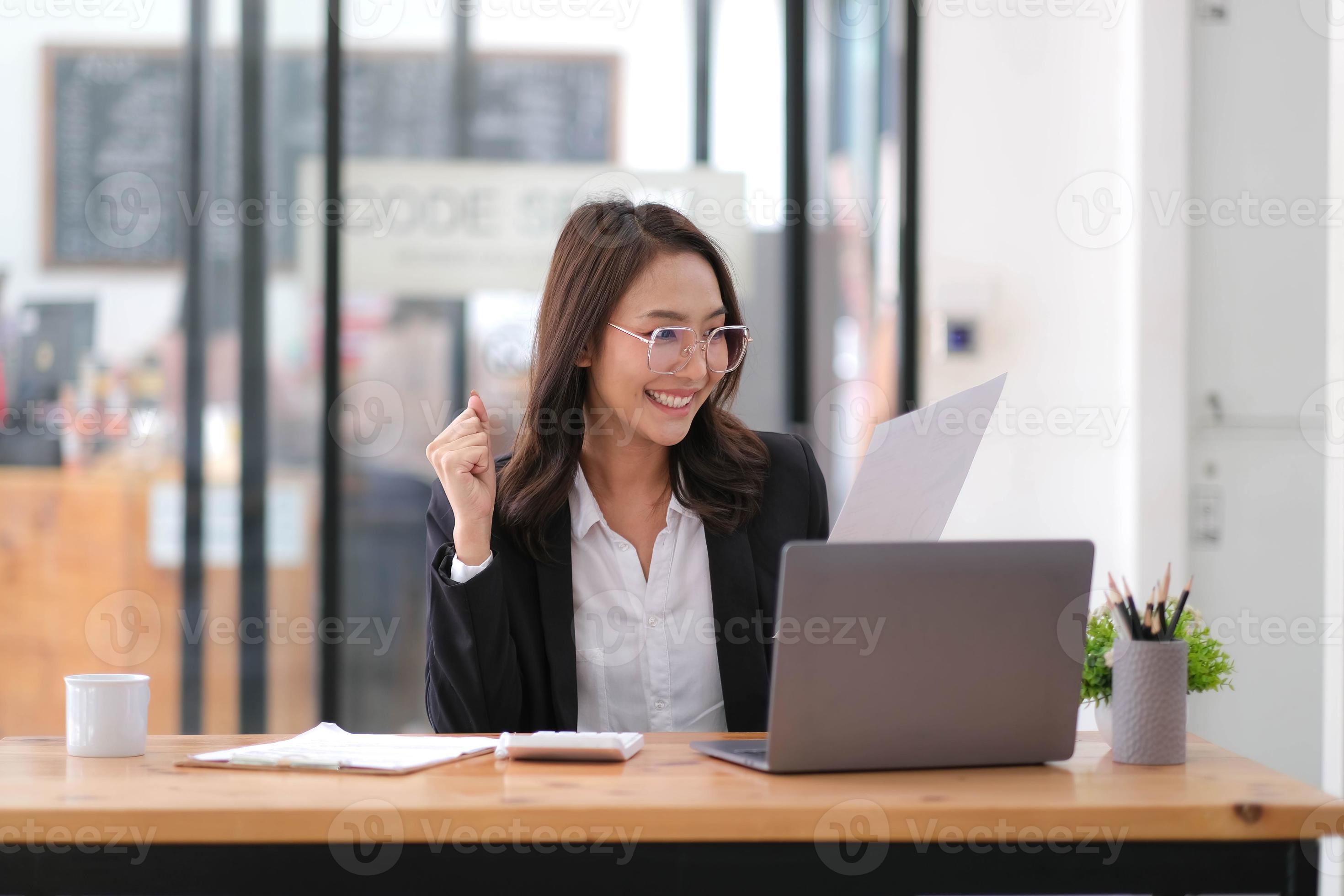 Happy excited successful Asian businesswoman triumphing with a laptop ...
