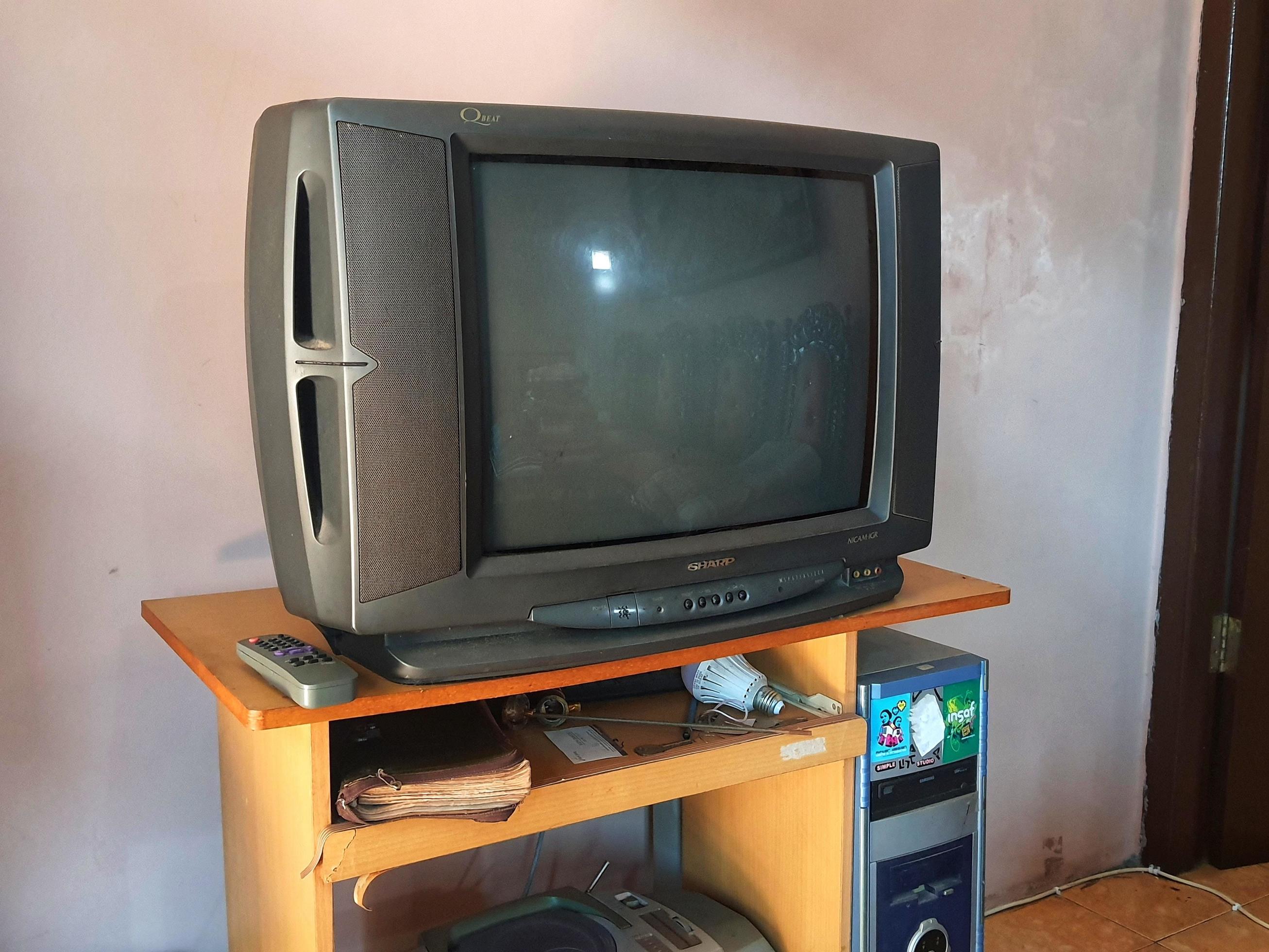 Ancient items on a computer desk. A sharp tube television, an ancient computer CPU, and a ...