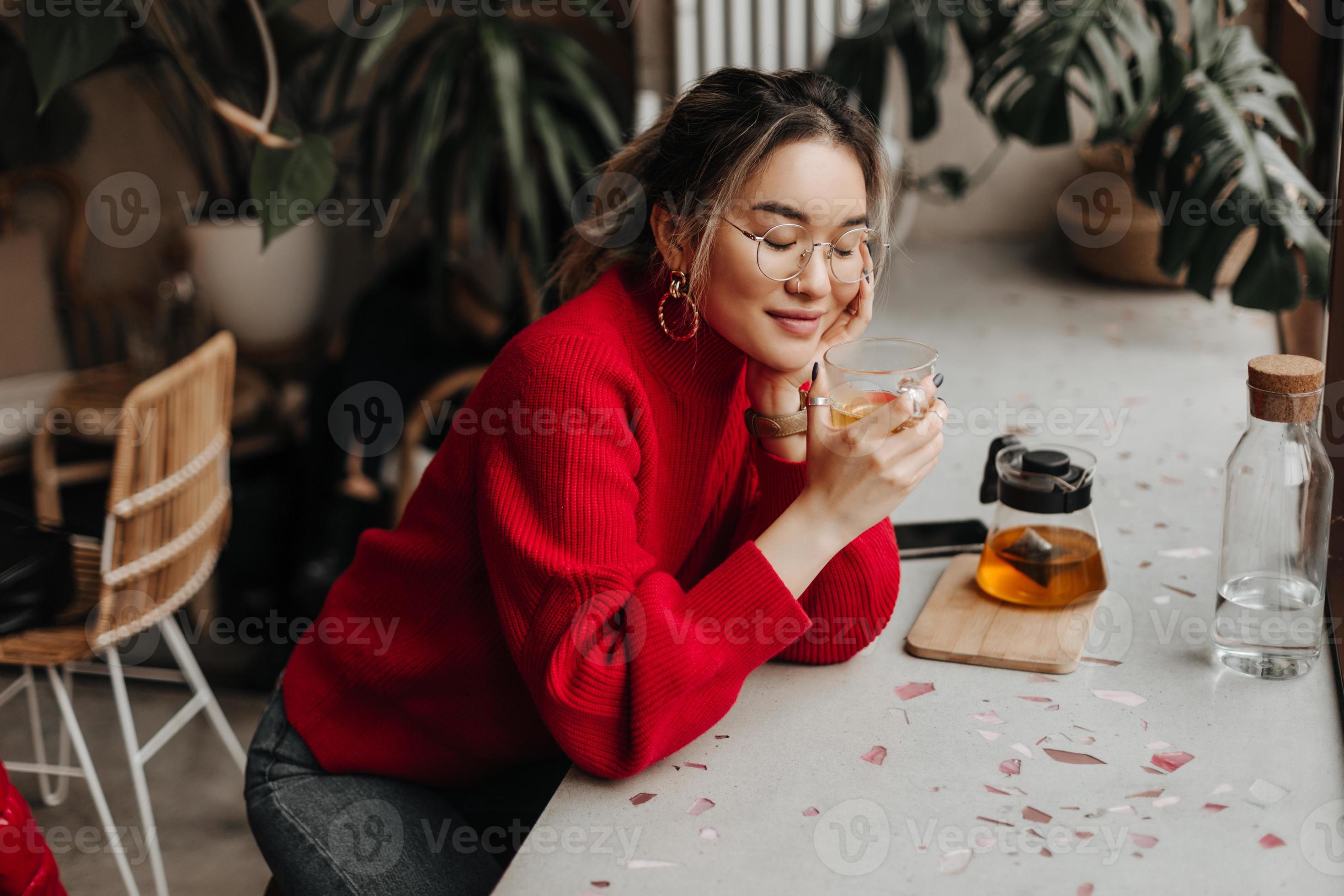 Young Girl In Glasses Leaned On Table In Cafe Woman In Red Sweater Enjoys Green Tea 12905871