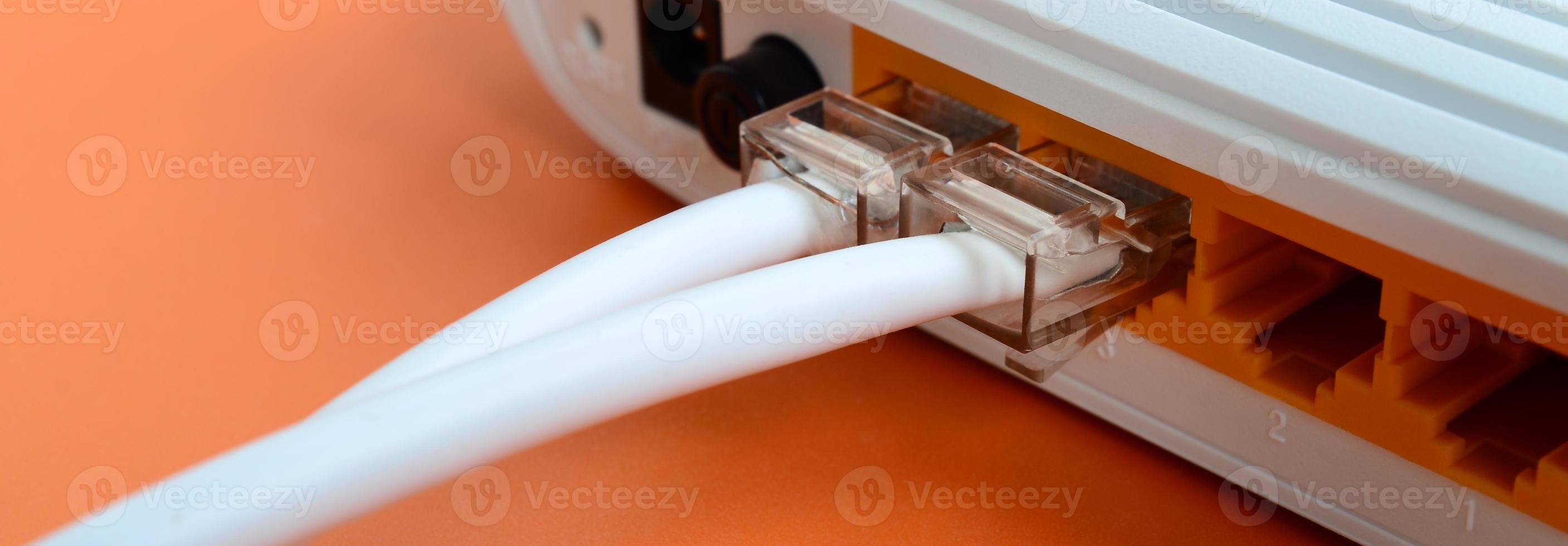 The Internet Cable Plugs Are Connected To The Internet Router Which Lies On A Bright Orange