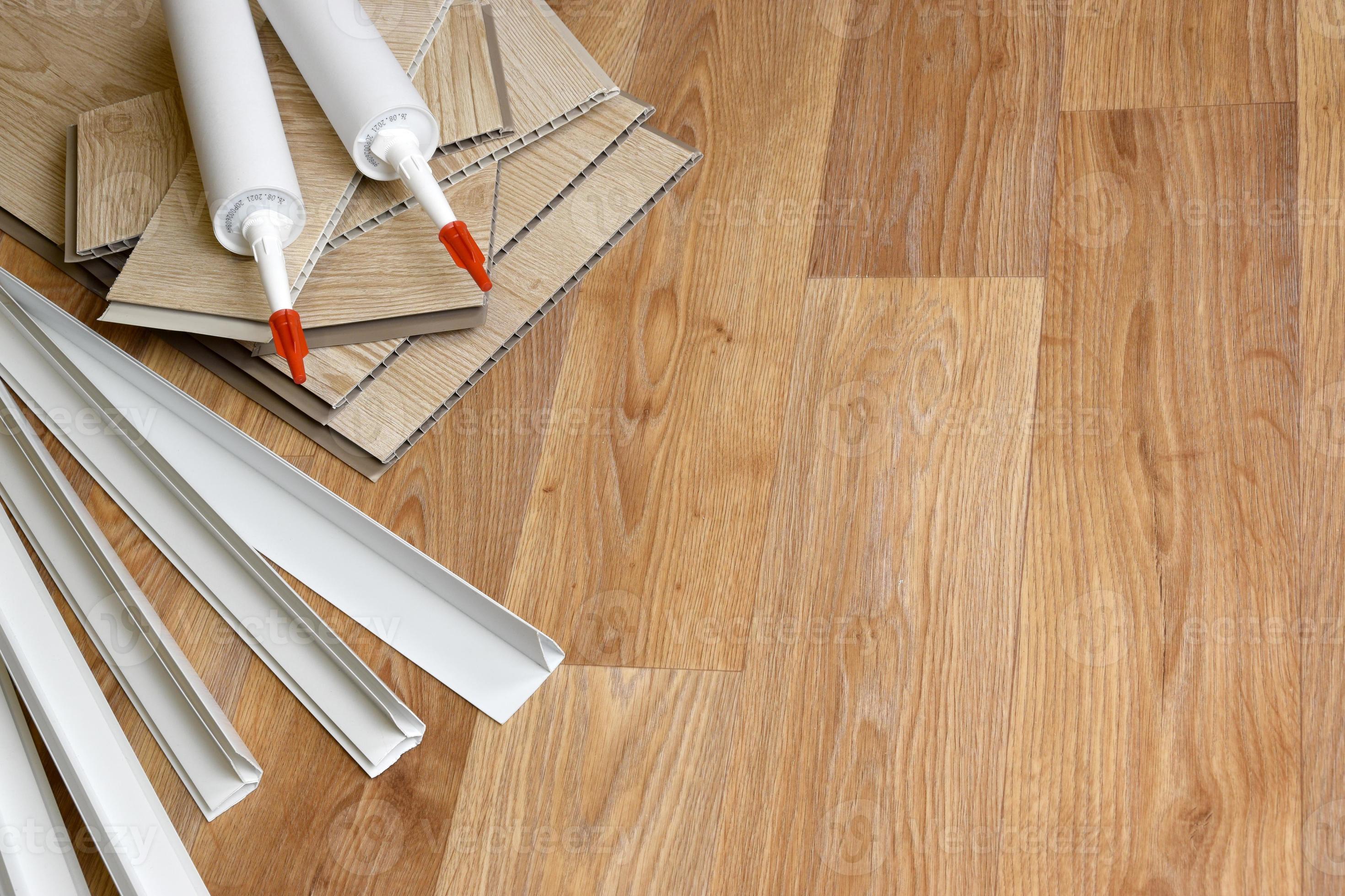 Set of items for PVC ceiling indoor works. Assembly adhesive bottles and PVC panels with plastic ...