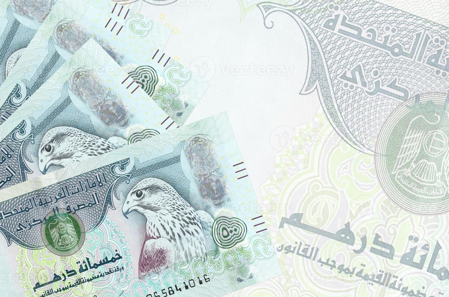 500 UAE dirhams bills lies in stack on background of big semi-transparent banknote. Abstract ...
