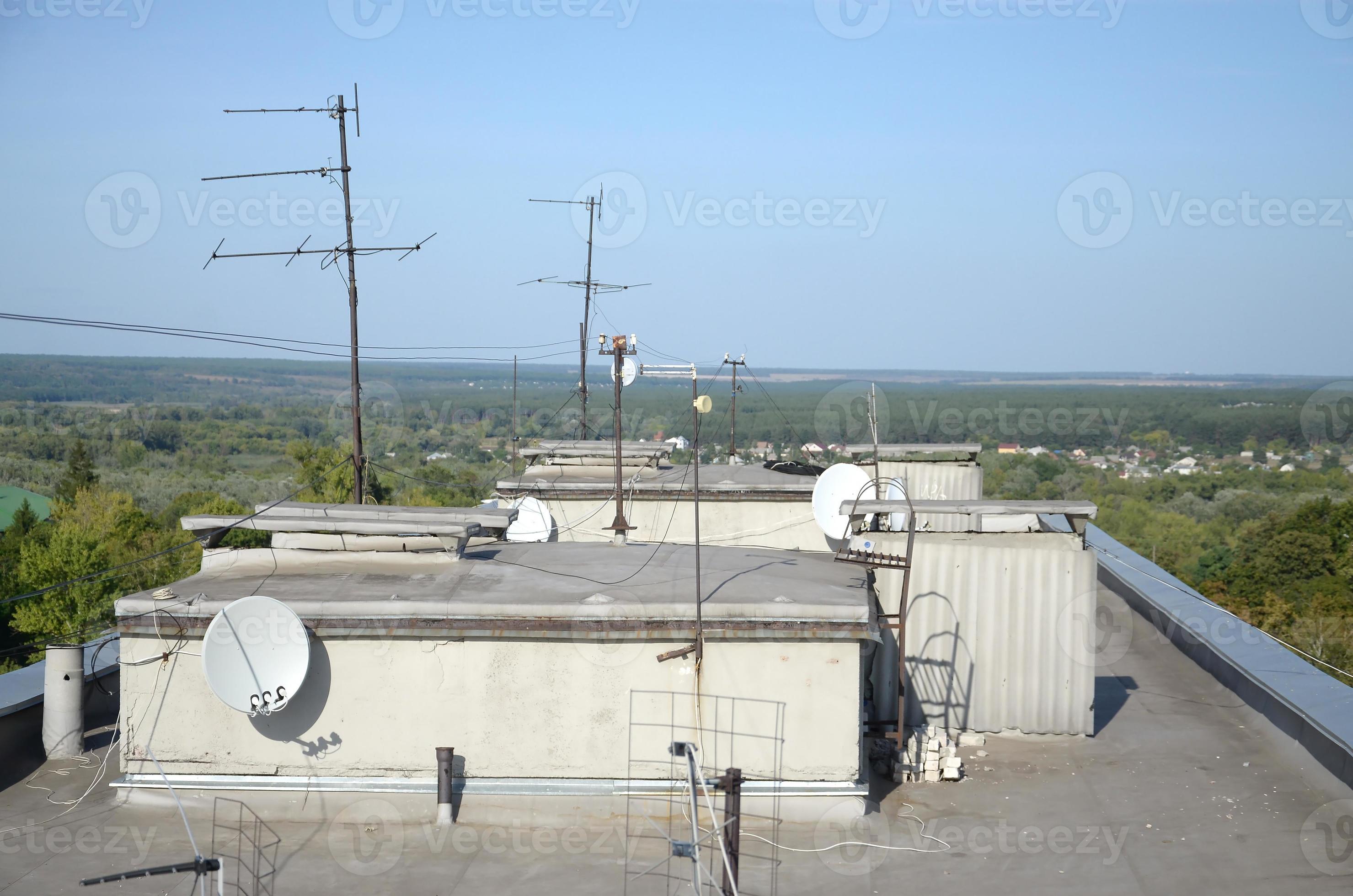 White satellite dish with three converters mounted on residental ...