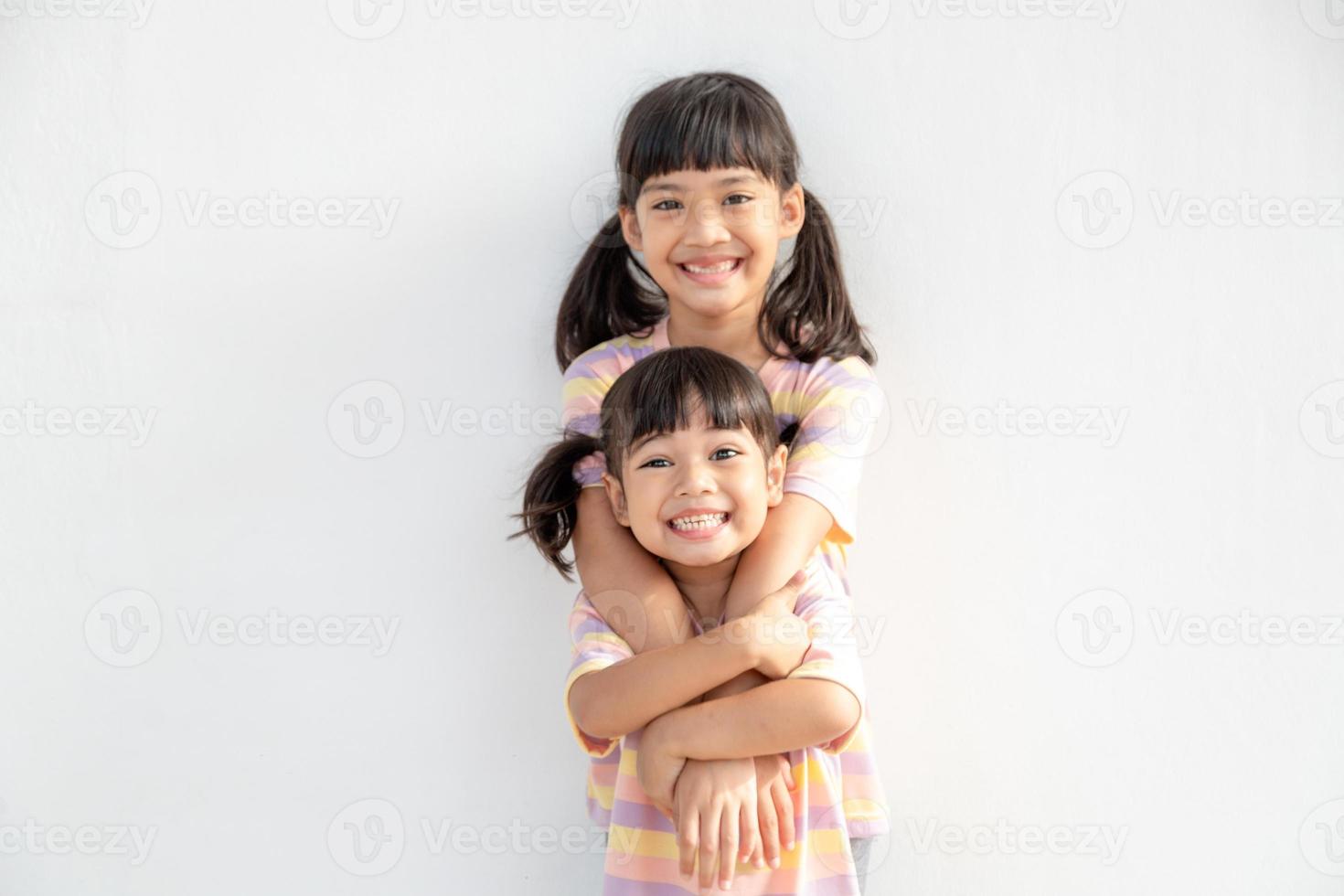 Cute happy Asian siblings hugging cuddling feeling love and connection ...