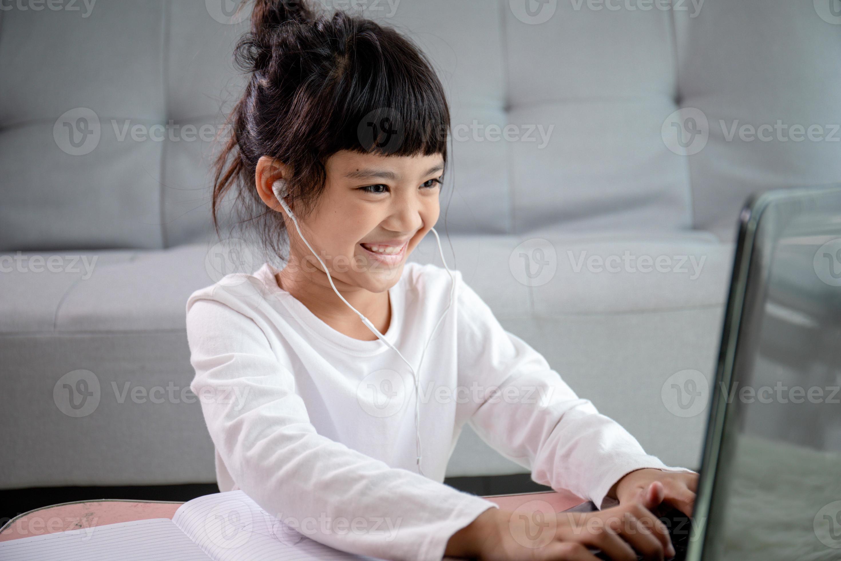 Asian girl students wear headphones study online with video call the teacher, Happy young girl ...