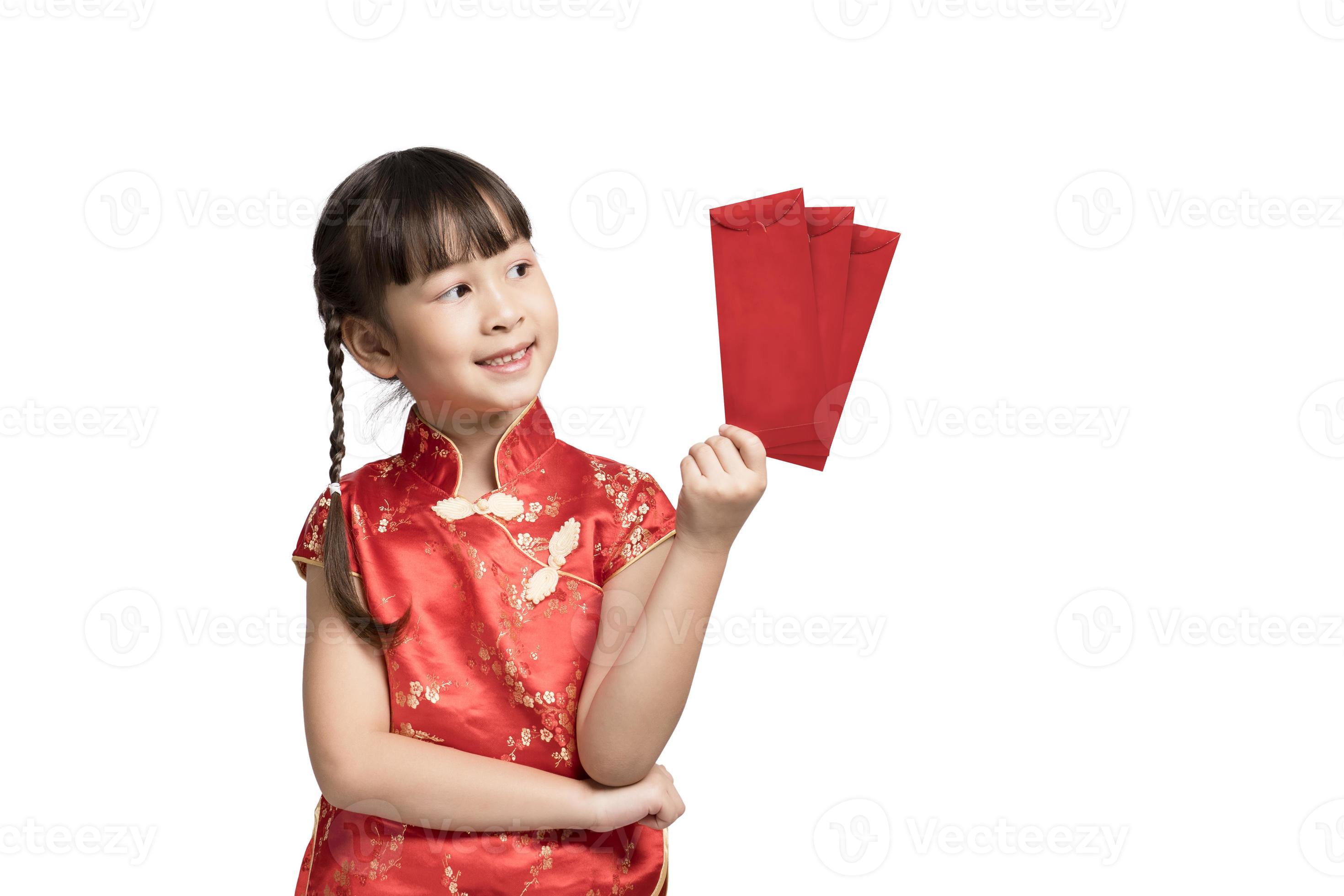 Happy smiling Asian girl in traditional Chinese dress with red envelope or Ang Pao on white ...