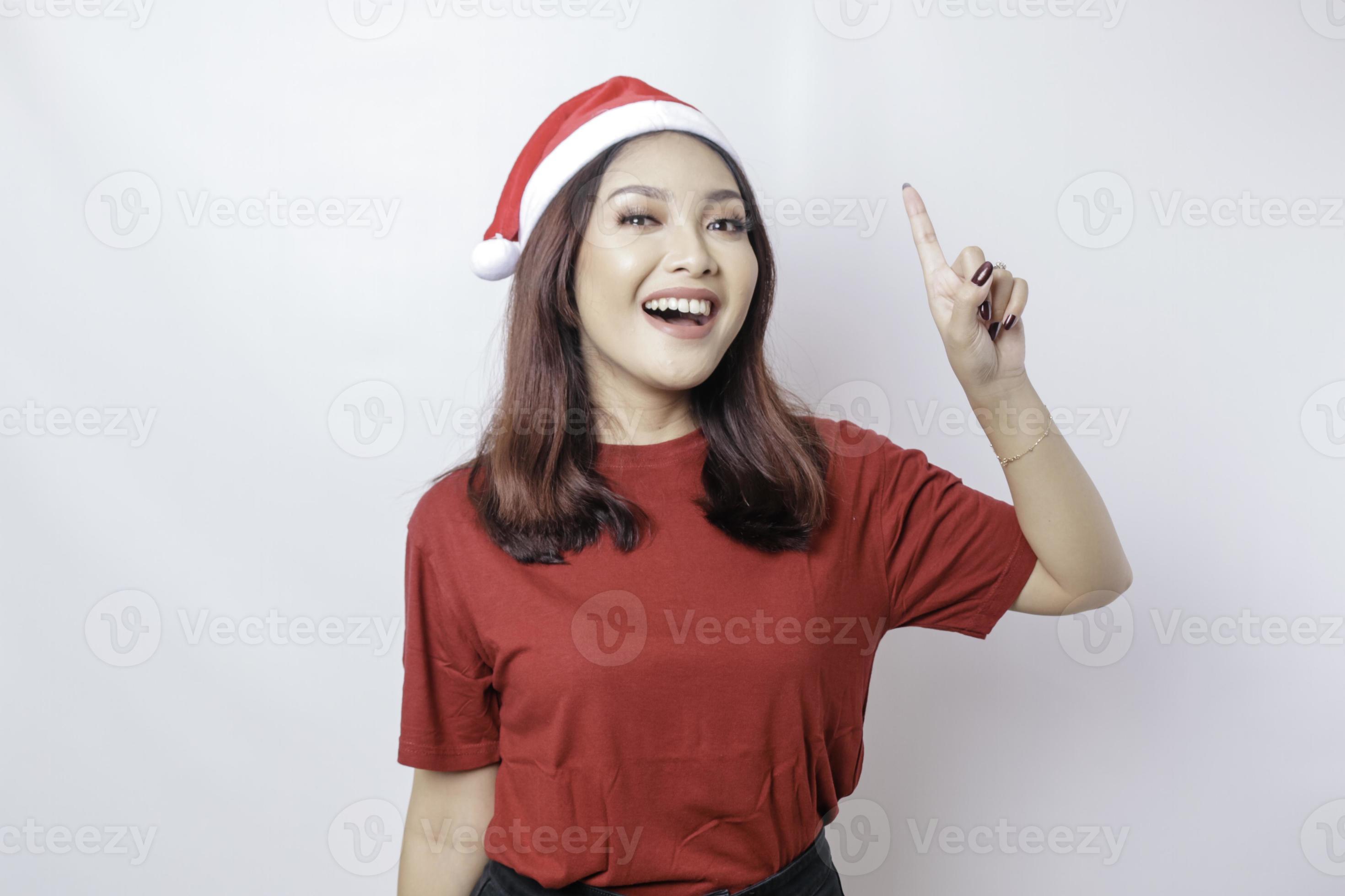 feliz mujer santa asiática está sonriendo y apuntando hacia arriba sobre ella aislada por un ...