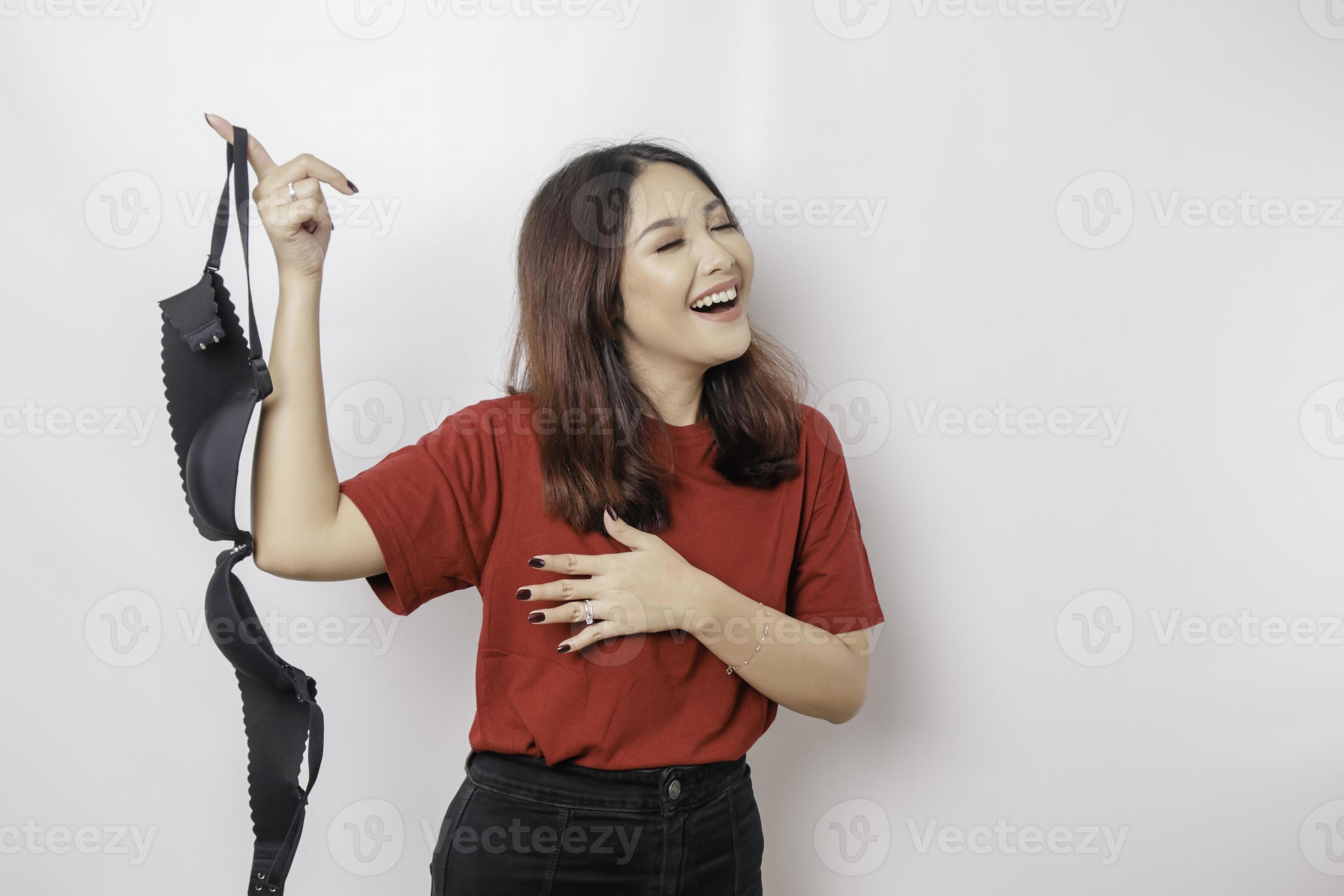 mujer sonriendo y sosteniendo un sostén contra el fondo blanco. concepto de concienciación sobre ...