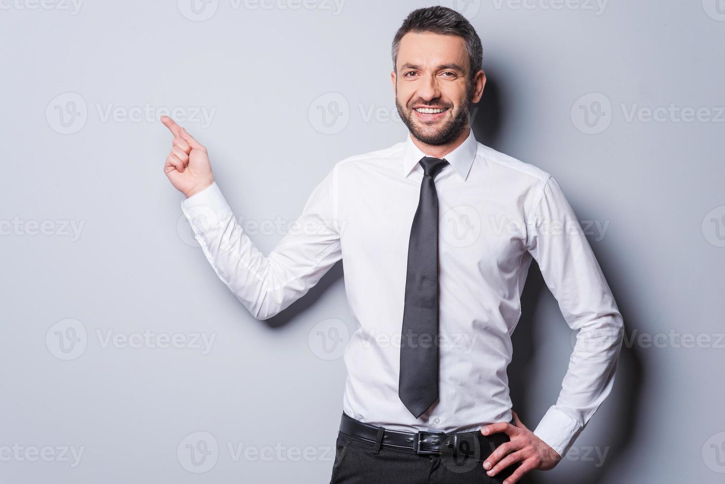 Copy space at his hand. Happy mature man in shirt and tie pointing copy ...