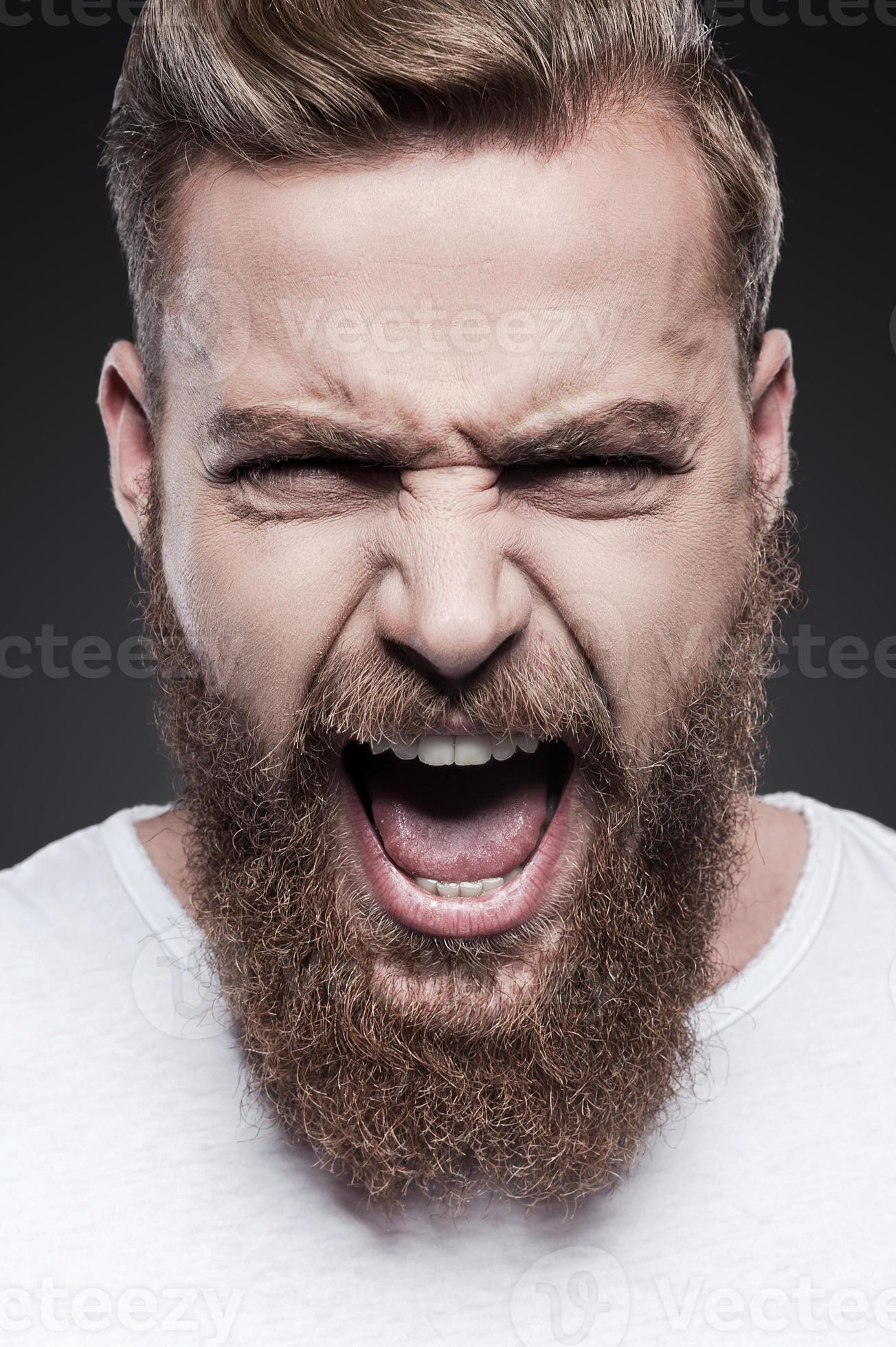 Unleashed emotions. Portrait of furious young bearded man shouting ...