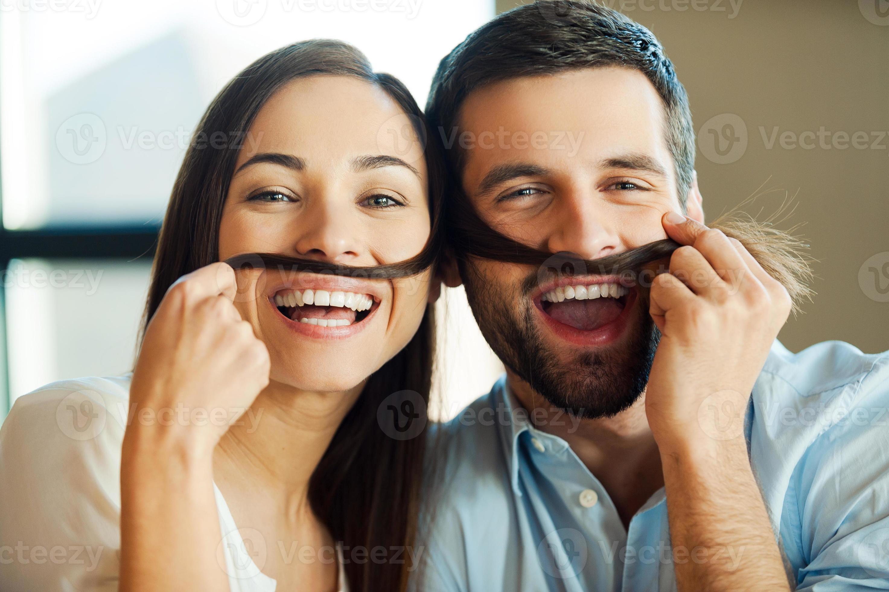 Playful couple. Beautiful young loving couple bonding to each other and smiling while making a ...