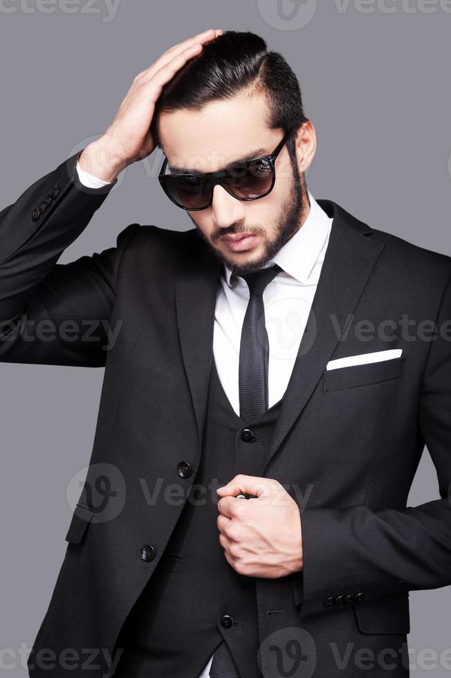 Stylish handsome. Handsome young man in formalwear touching his hair ...