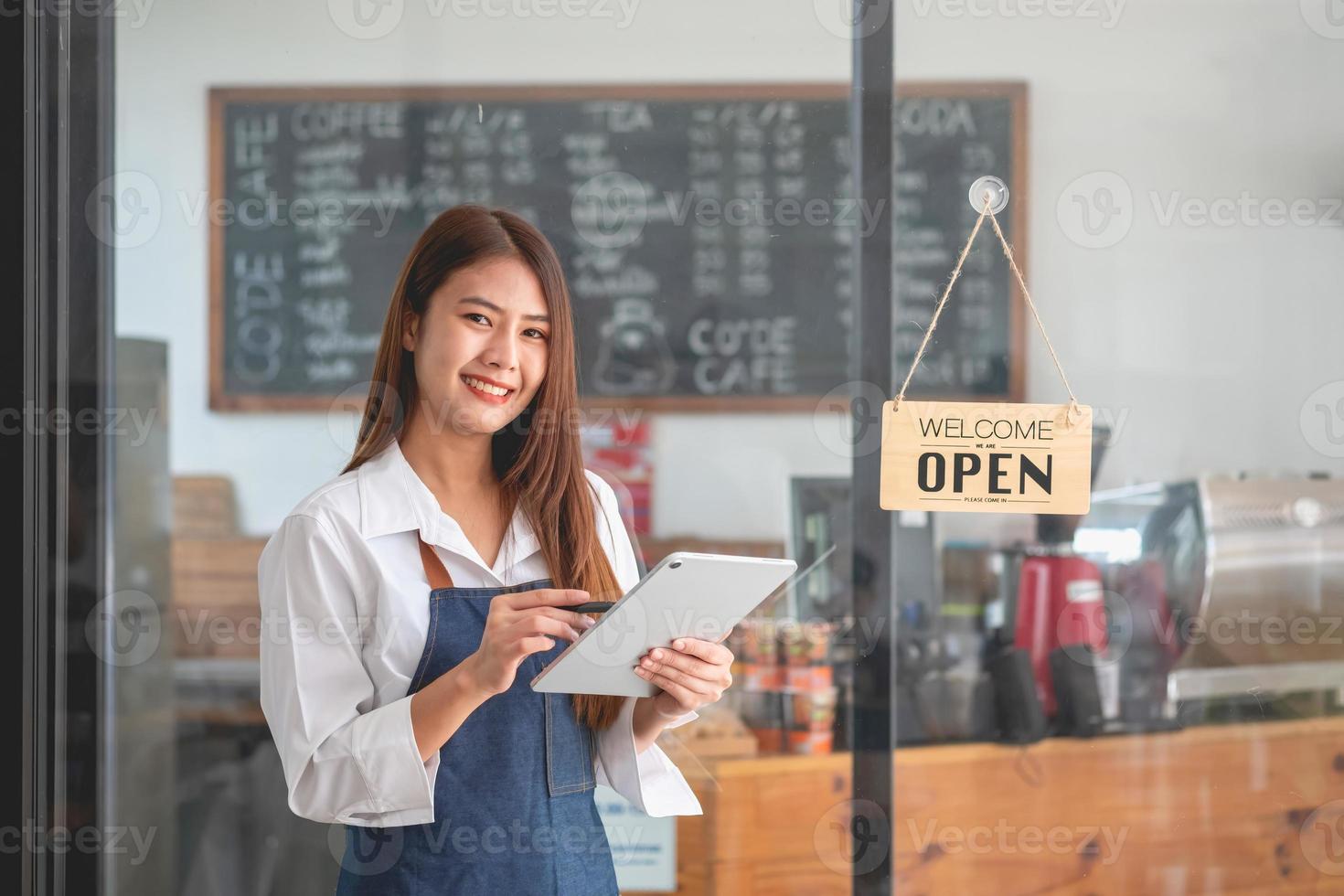 retrato de una mujer, propietaria de un negocio de cafetería que sonríe hermosamente y abre una ...