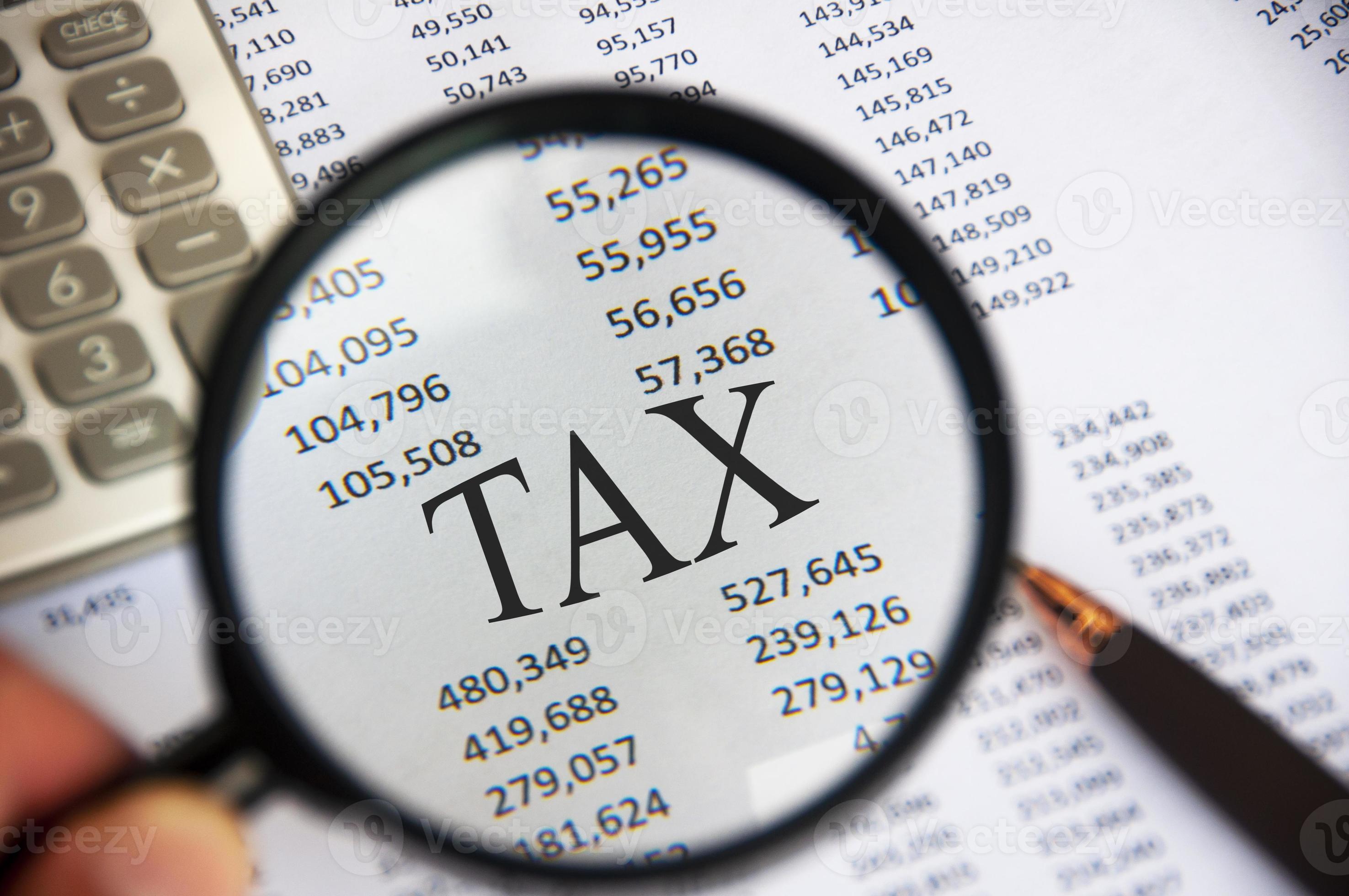 Magnifying glass focusing on TAX word on analysis paper. Tax concept 13354262 Stock Photo at ...