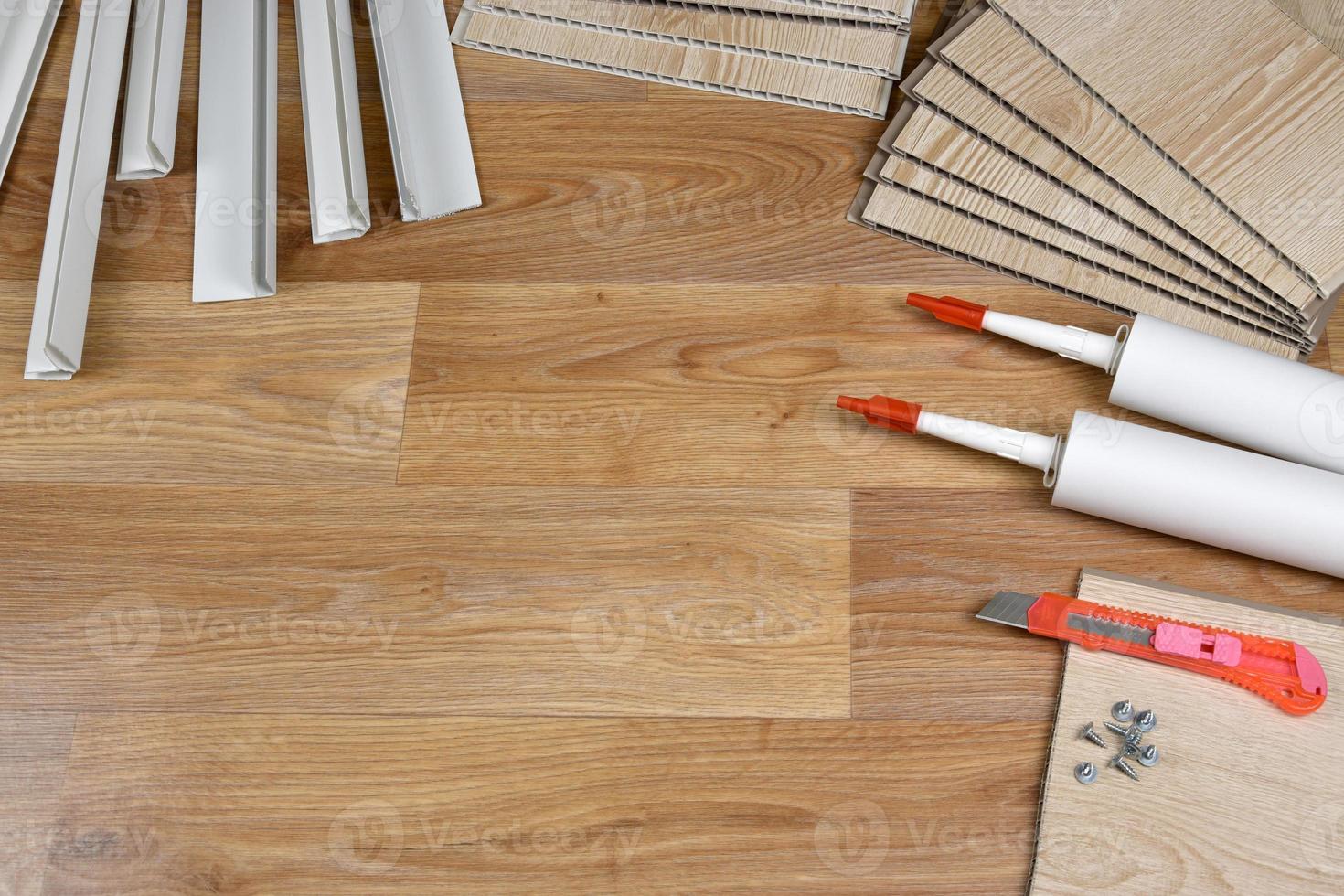 Set of items for PVC ceiling indoor works. Assembly adhesive bottles and PVC panels with plastic ...