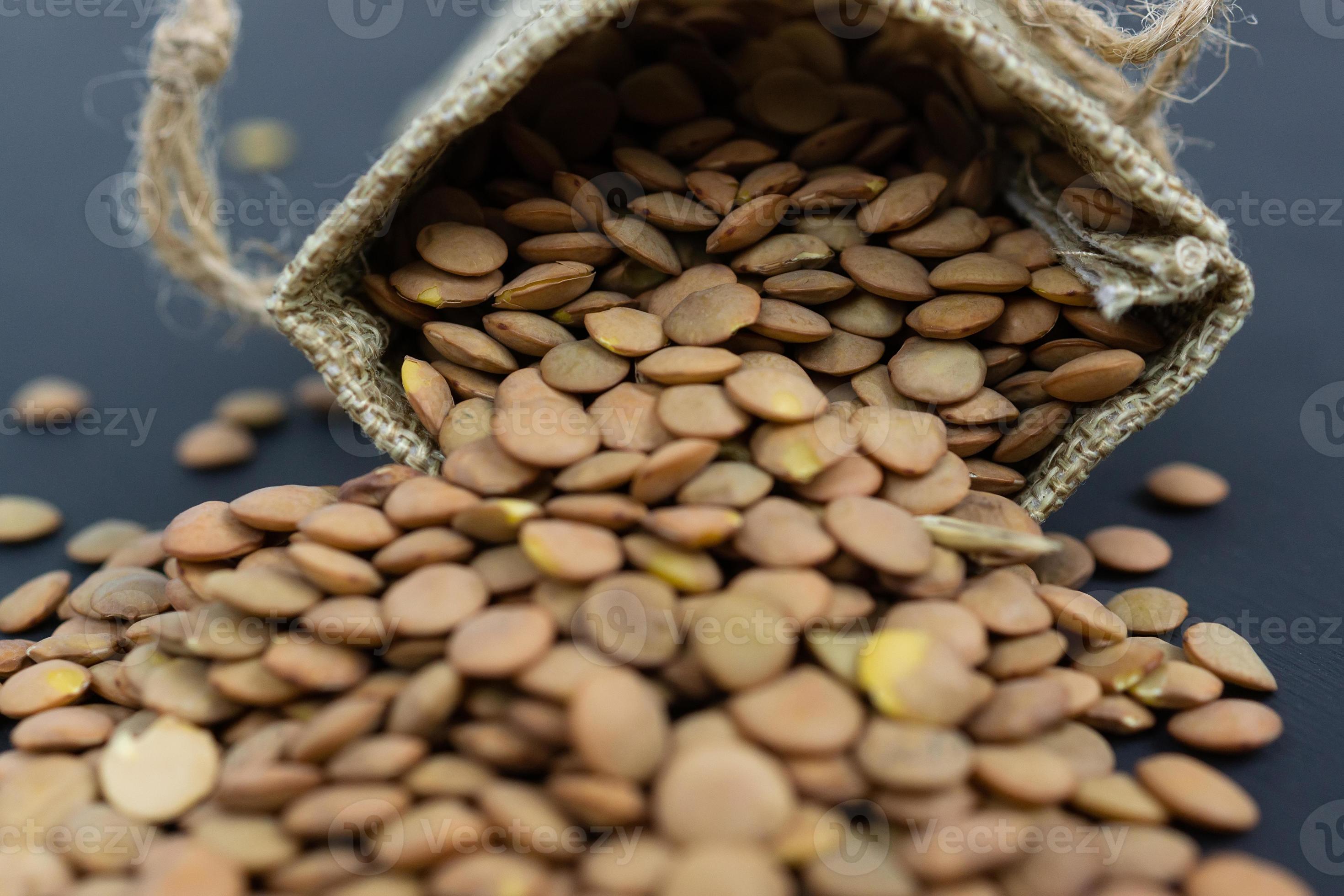 brown dried lentils in a burlap bag on black background 13427600 Stock Photo at Vecteezy
