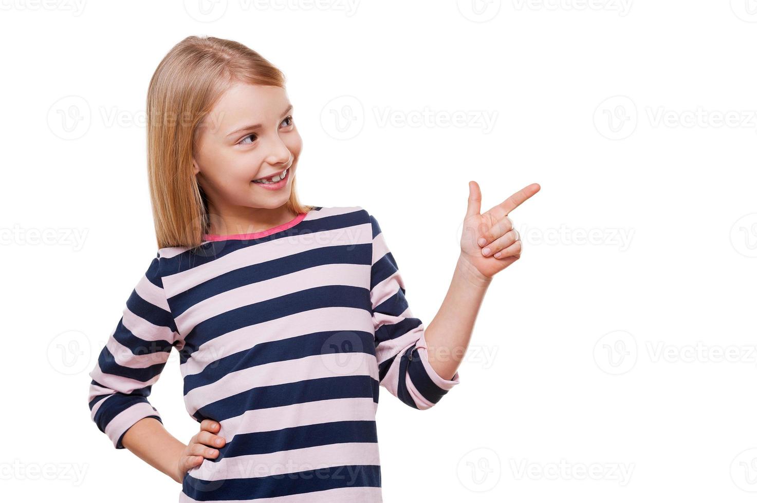 Showing the right direction. Cheerful little girl pointing away and ...