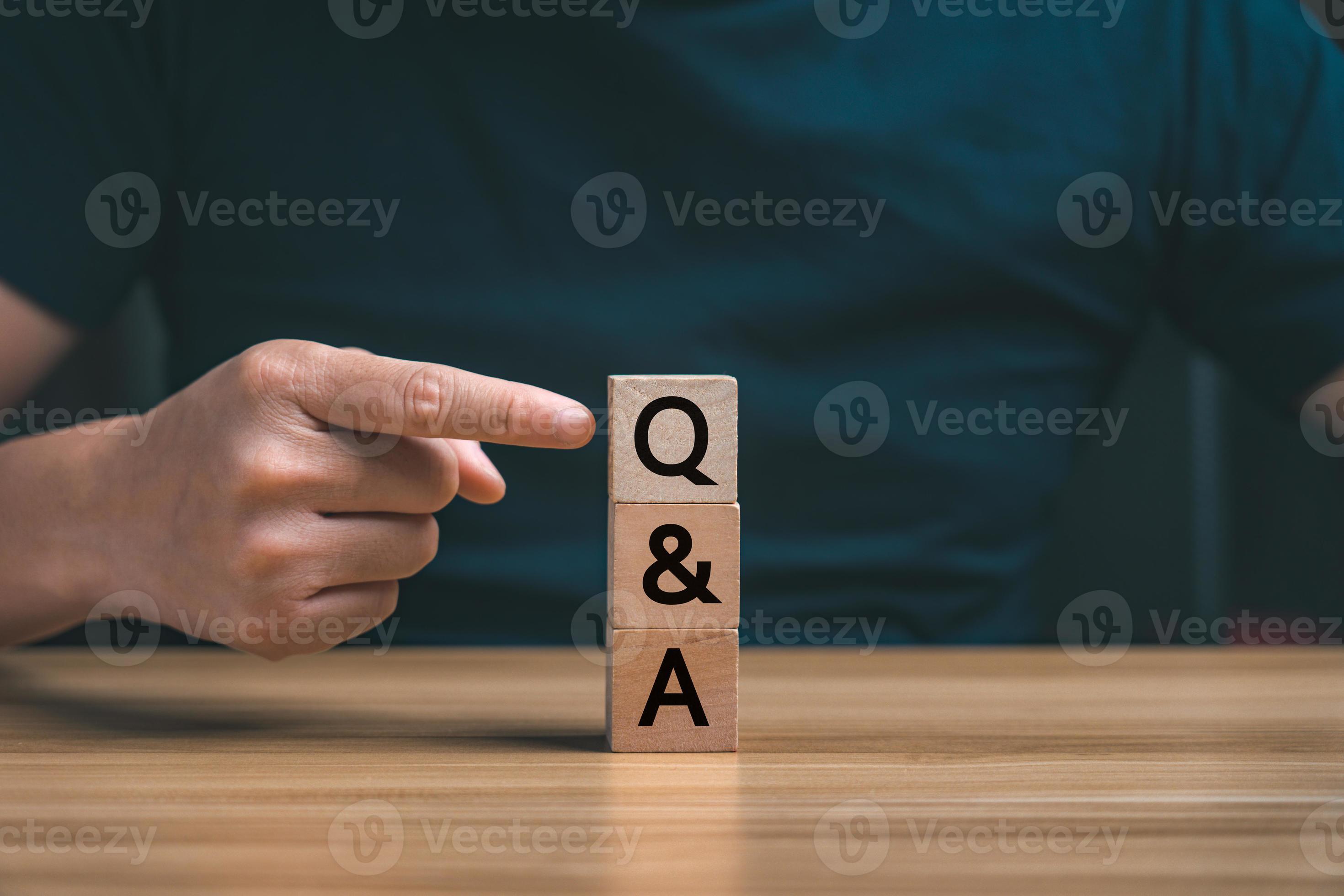 questions and answers. businessman hand choose Q and a on a wooden ...