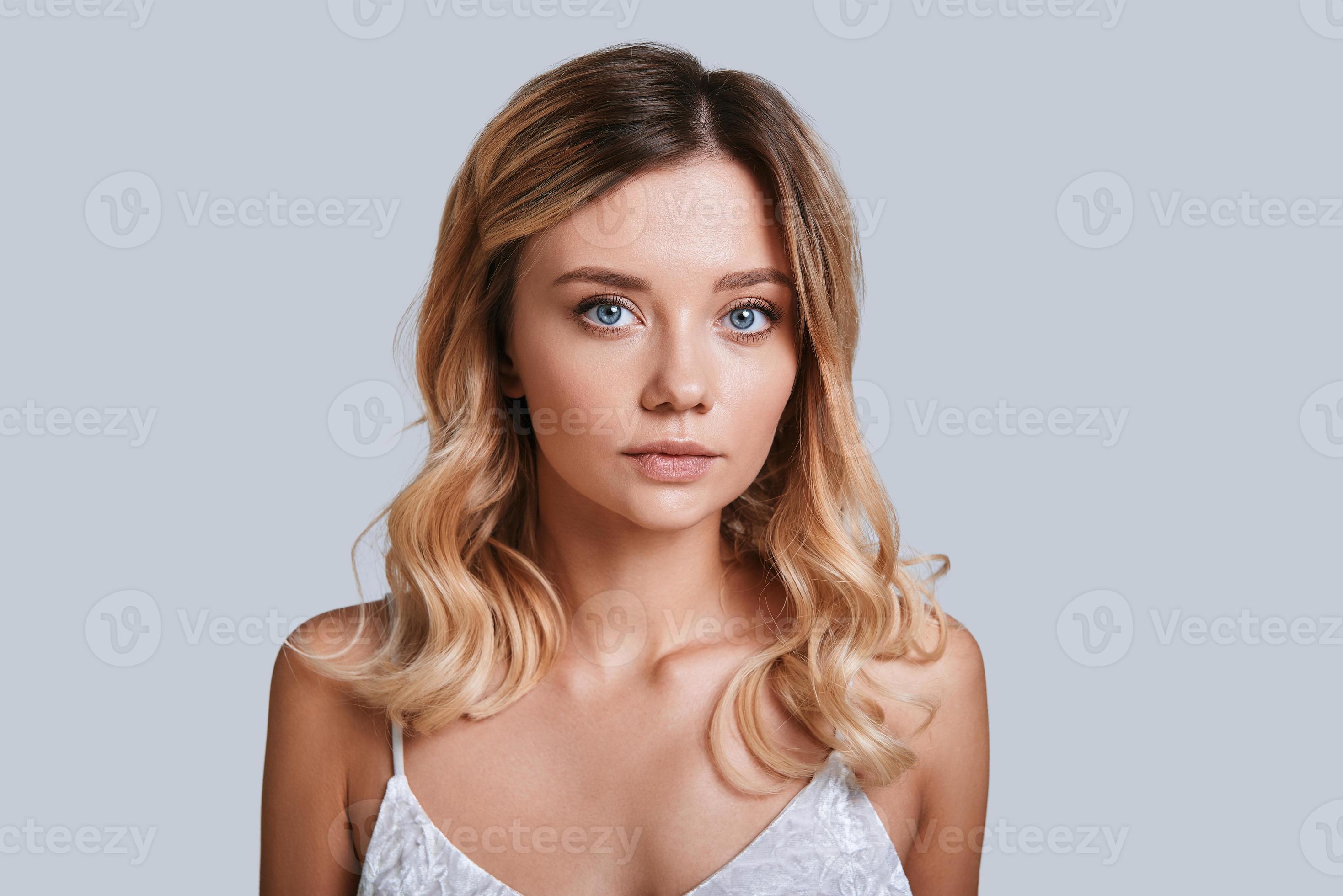 Glowing with natural beauty. Attractive young woman looking at camera ...