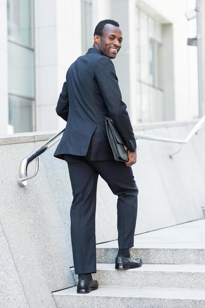 Cheerful businessman. Cheerful young African man in formalwear moving ... Cheerful businessman. Cheerful young African man in formalwear moving ...