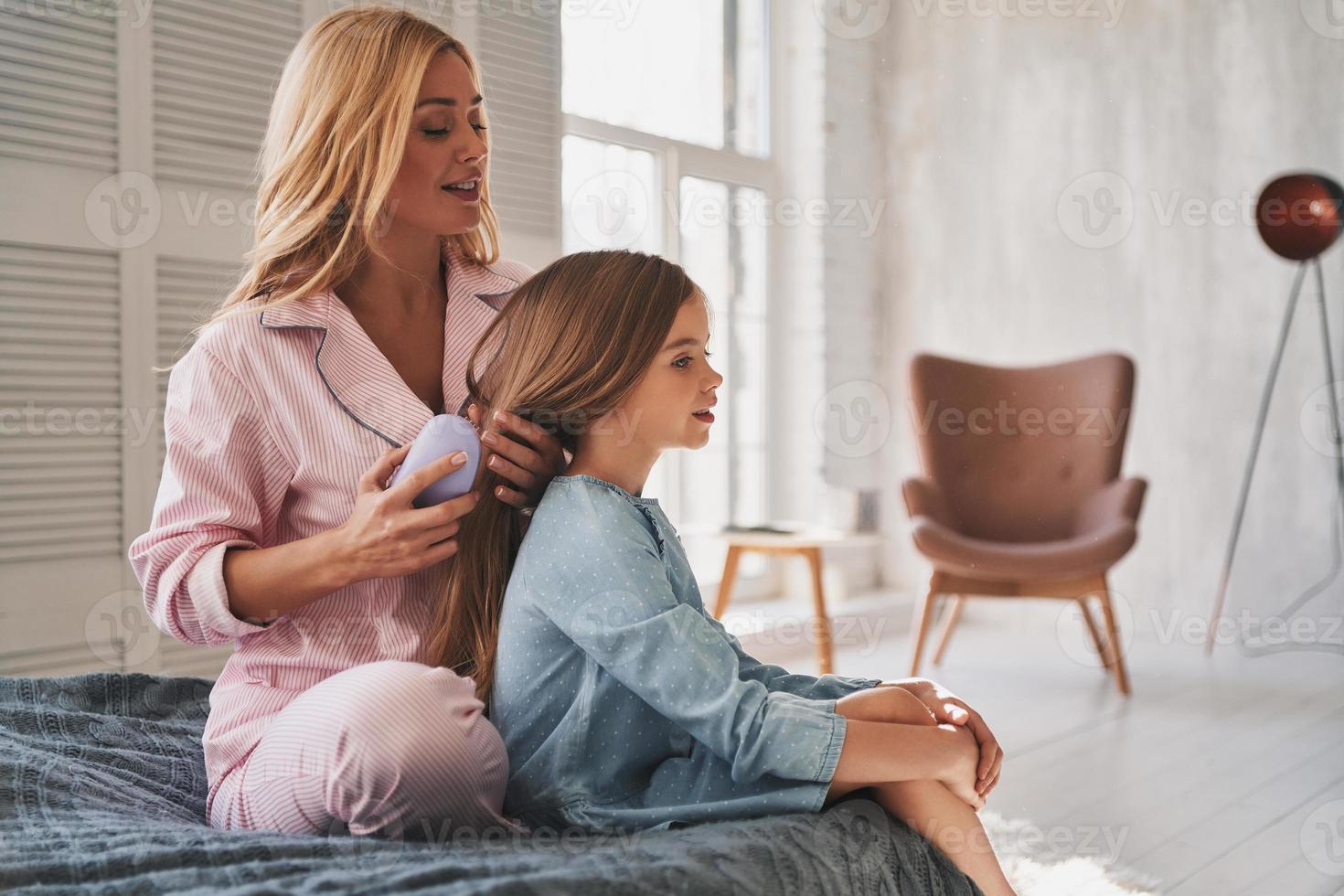 Beautiful Young Mother Brushing Her Daughters Hair While Sitting On The