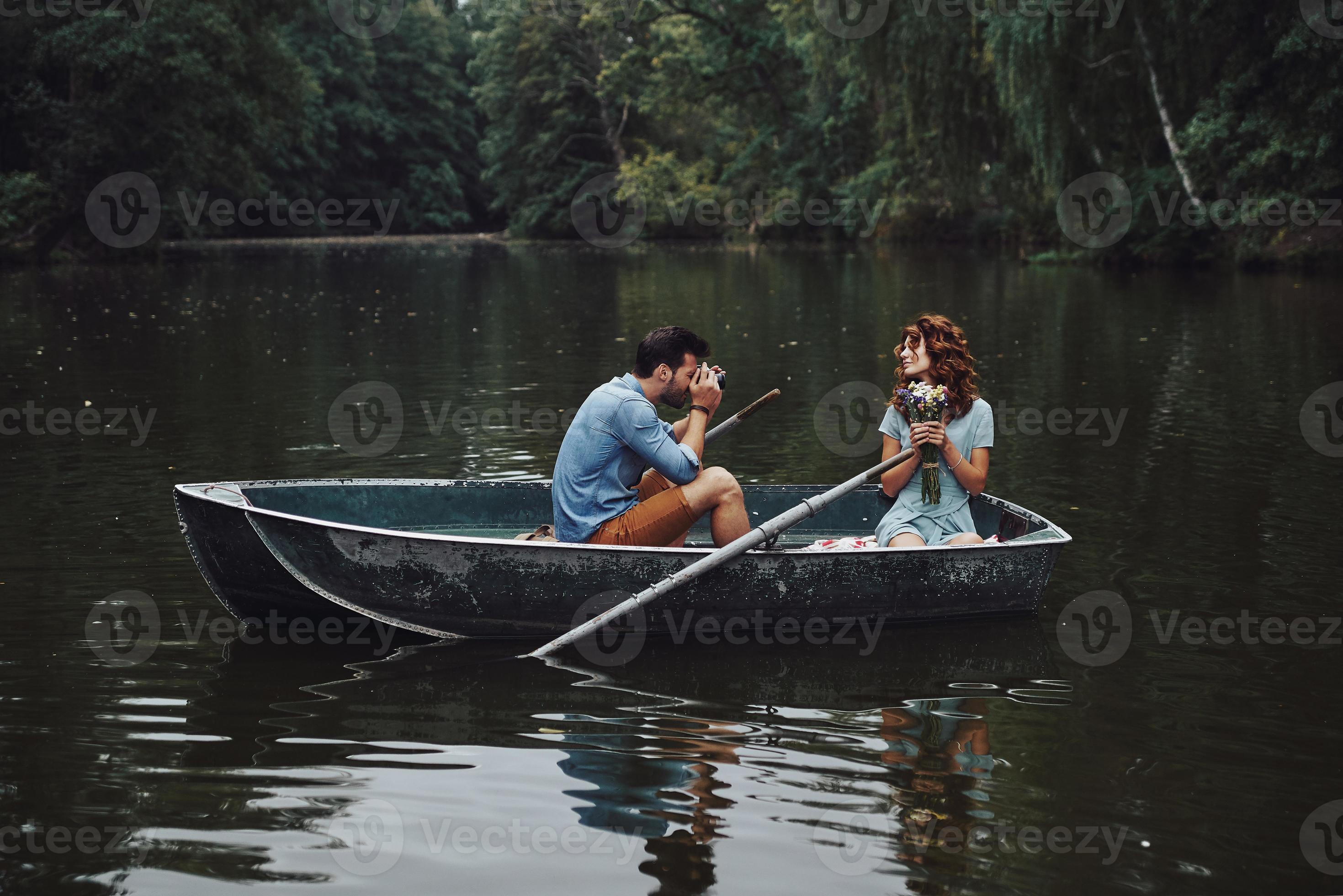 Great shot. Young man photographing his beautiful girlfriend while enjoying romantic date on the ...