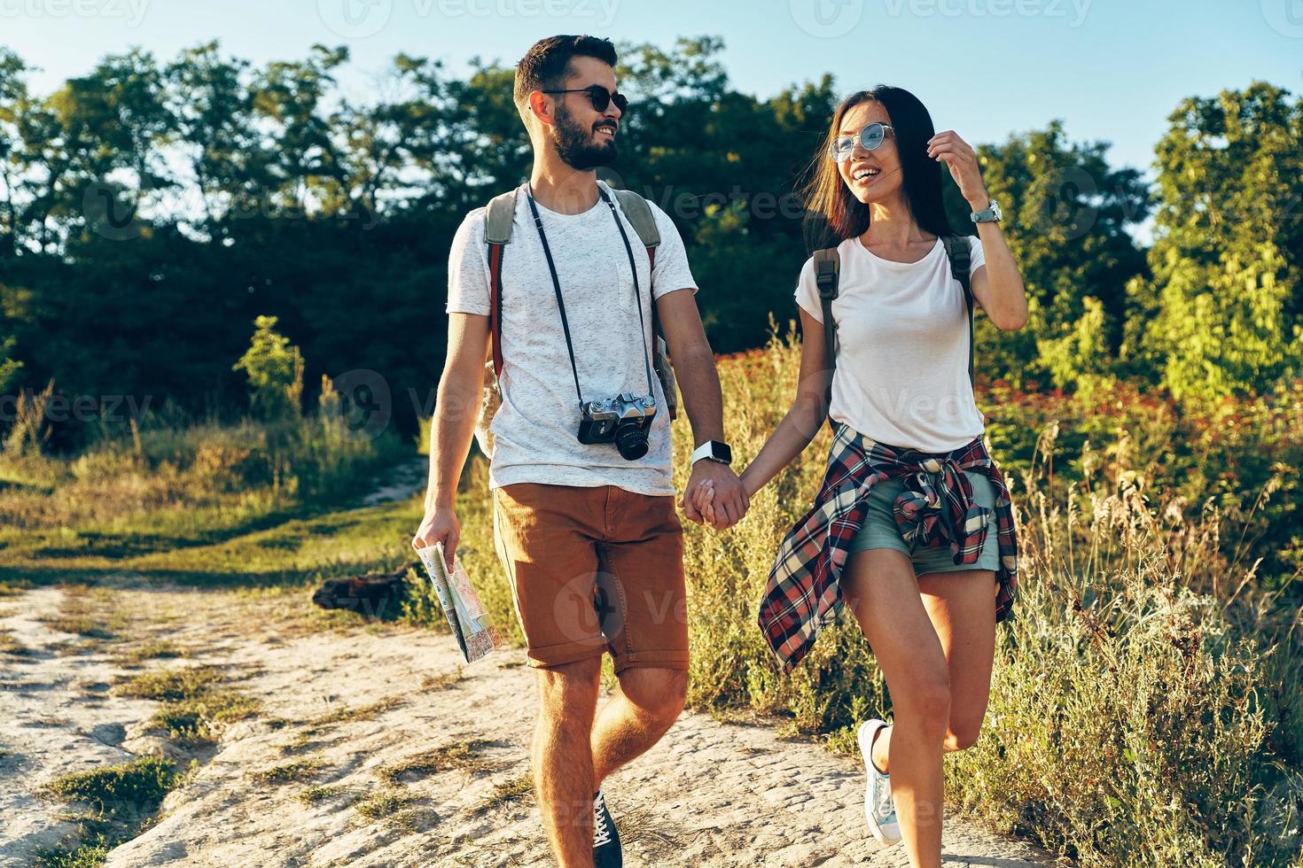Beautiful Young Romantic Couple Of Tourists Holding Hands And Smiling While Walking Outdoors