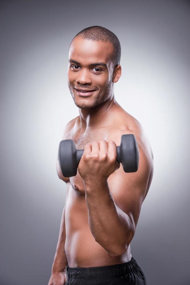 Training his body to perfection. Young shirtless African man exercising ...