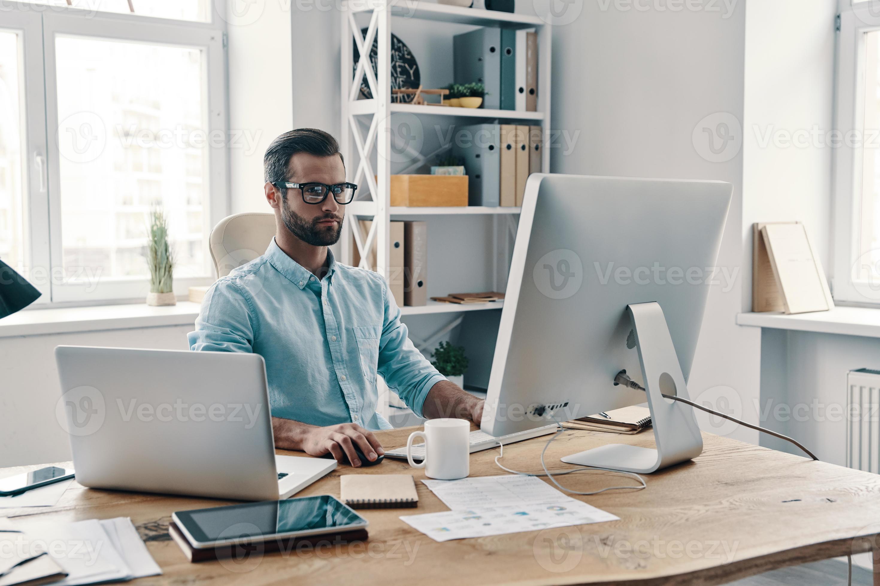 Inspired to work hard. Young modern businessman working using computer ...
