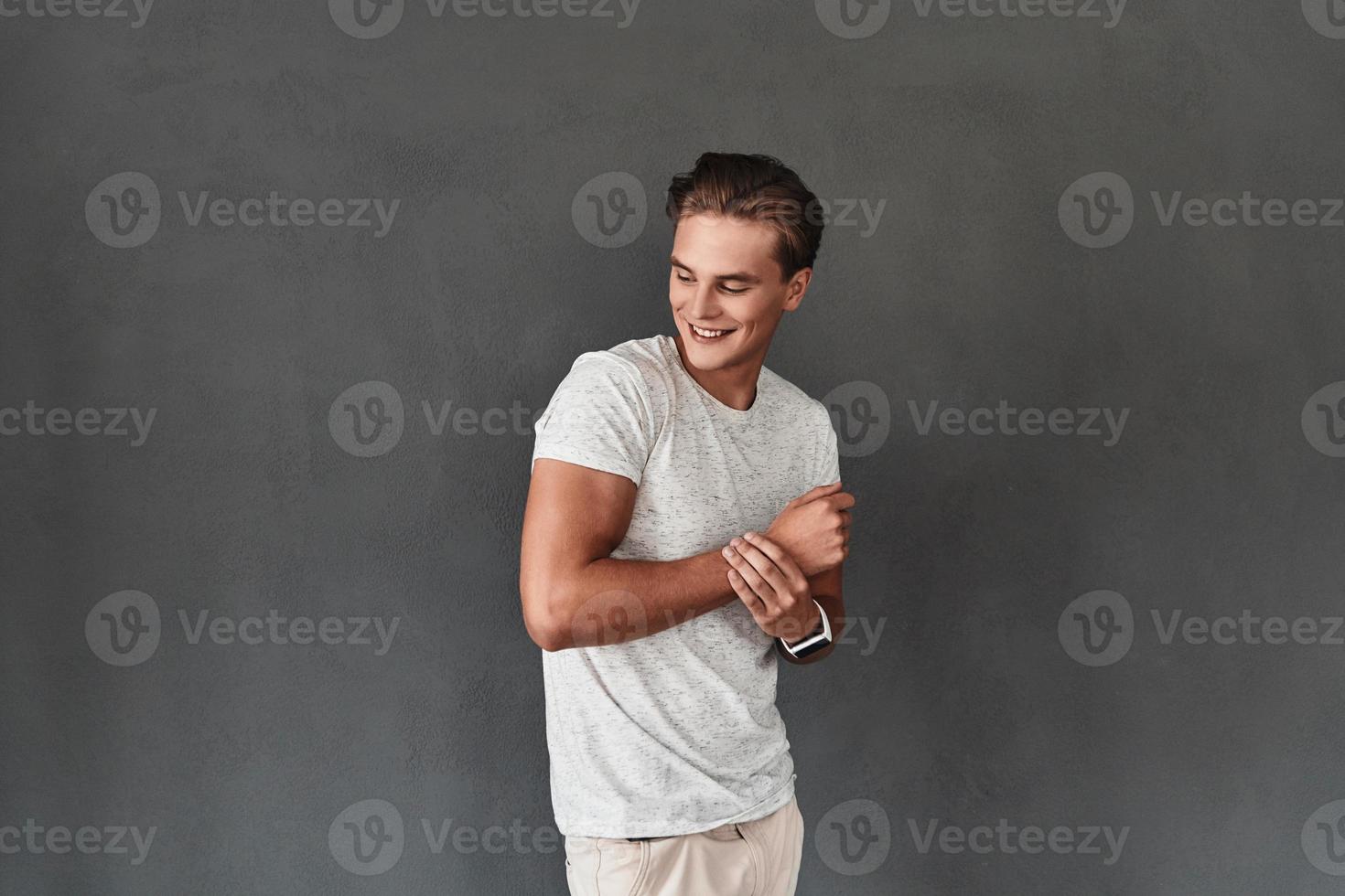 He got candid smile. Handsome young man looking away and smiling while ...