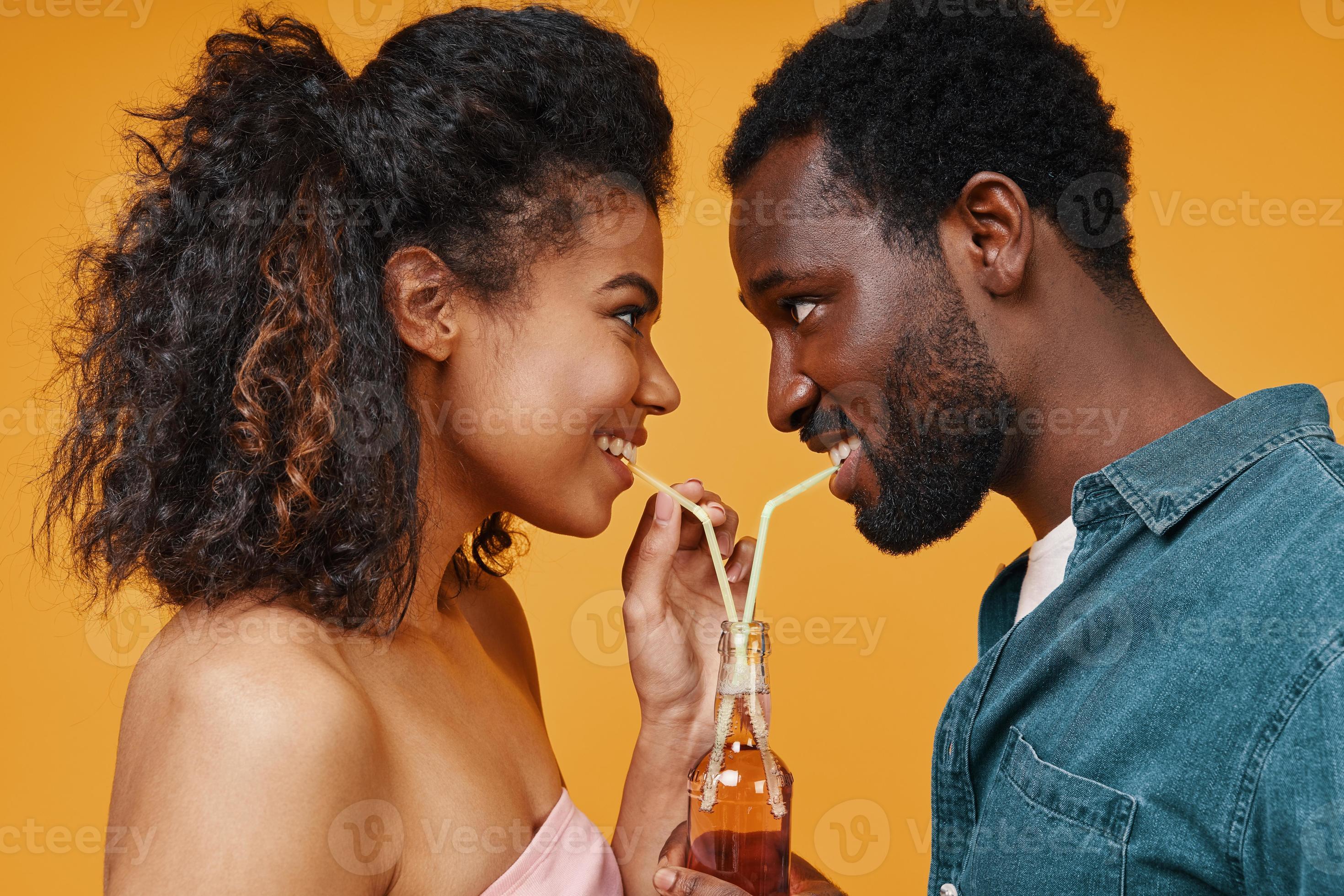 Beautiful young African couple drinking juice and smiling while standing face to face 13540976 ...