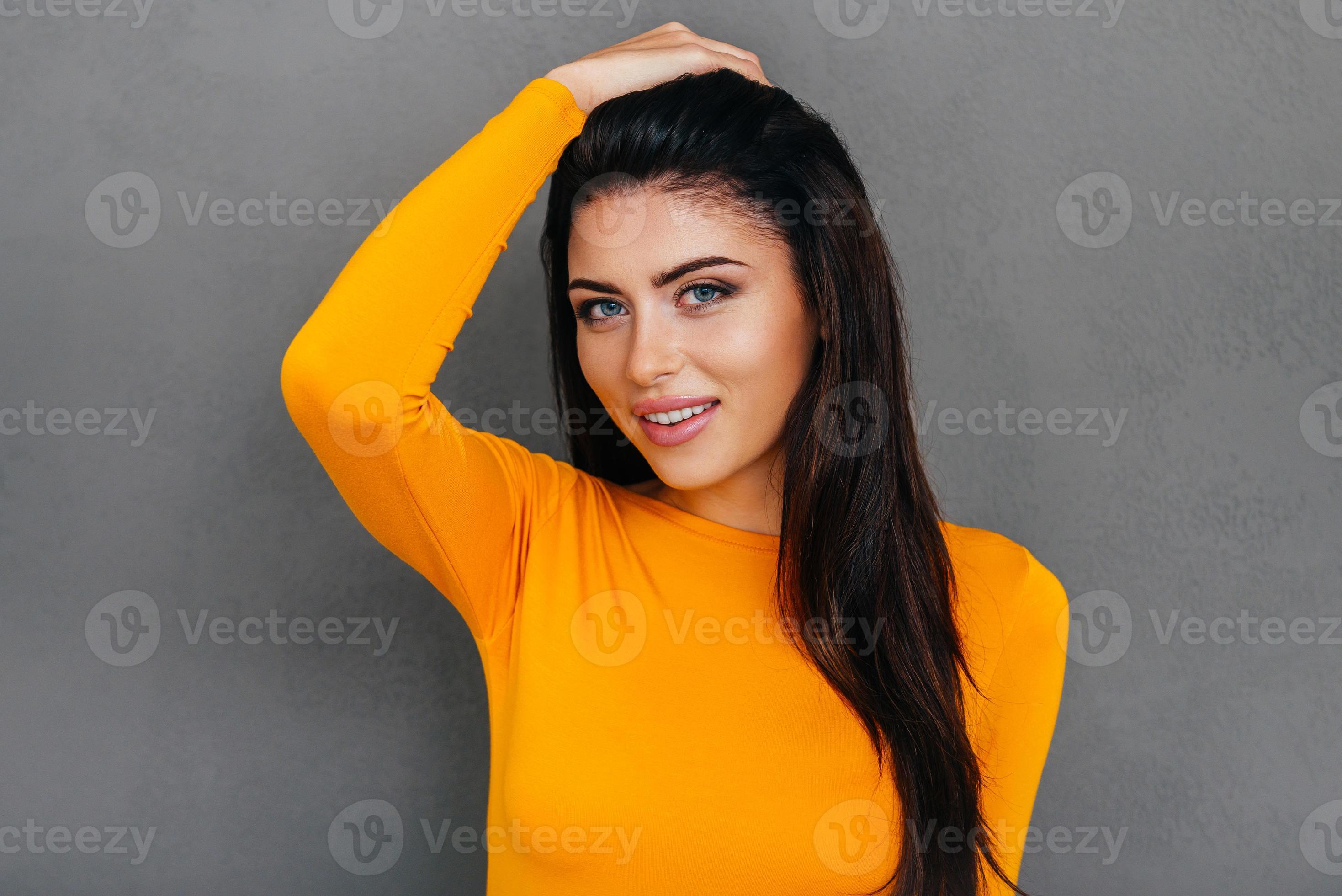 Simply beautiful. Beautiful young woman holding hand in hair and ...