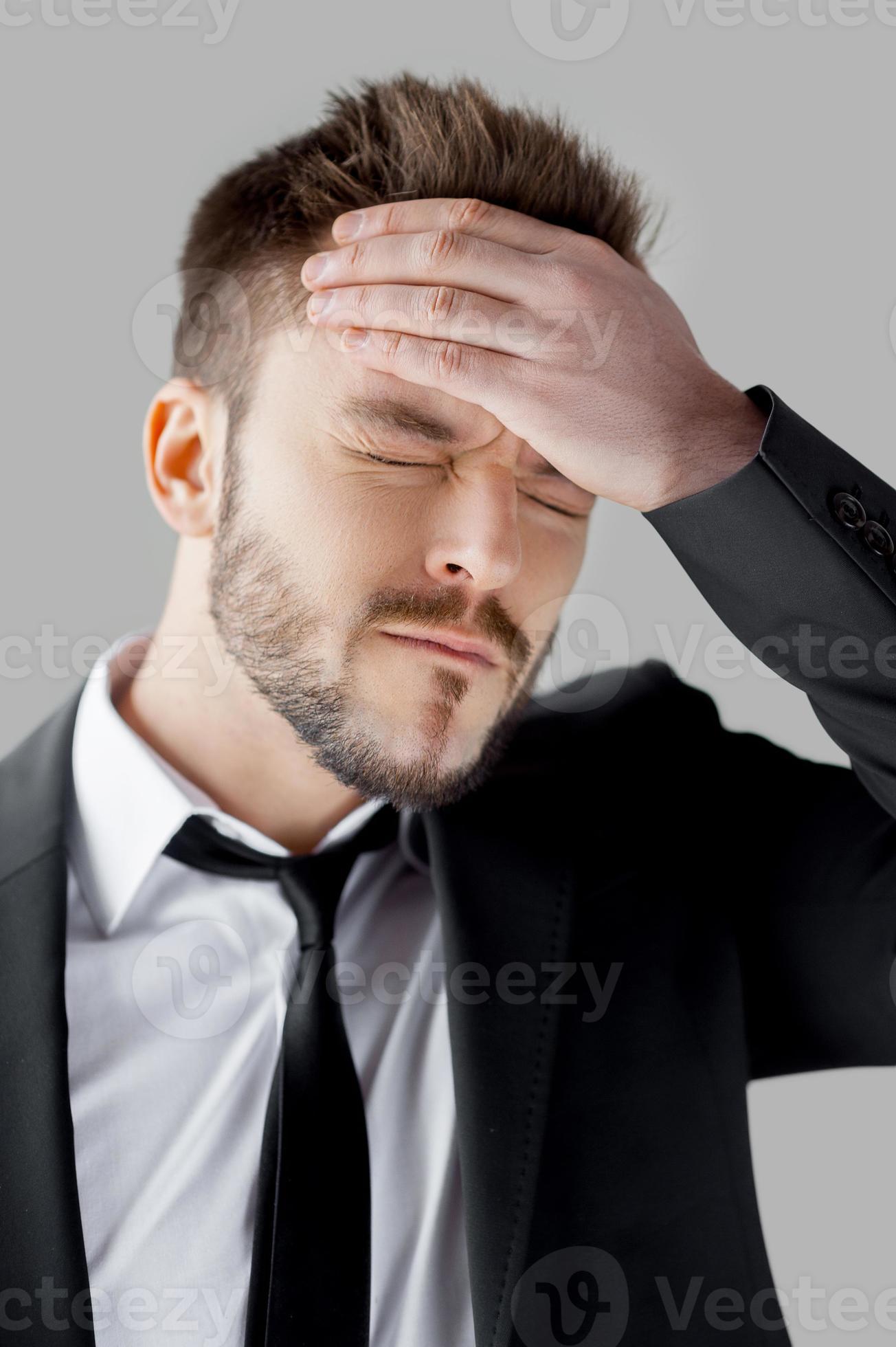 Oh no Portrait of frustrated young man in formalwear holding hand in ...