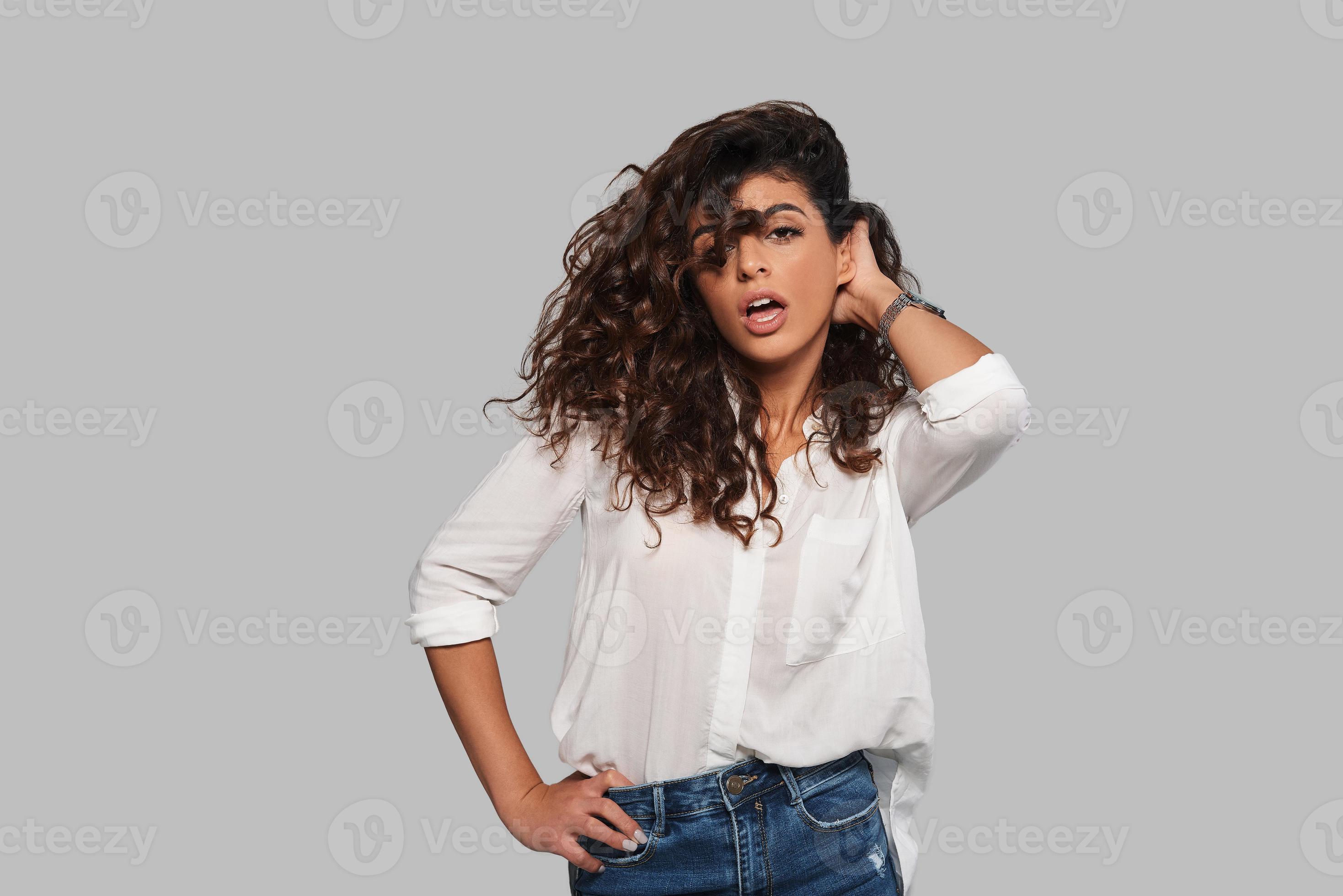 In her own style. Attractive young woman playing with her hair and ...