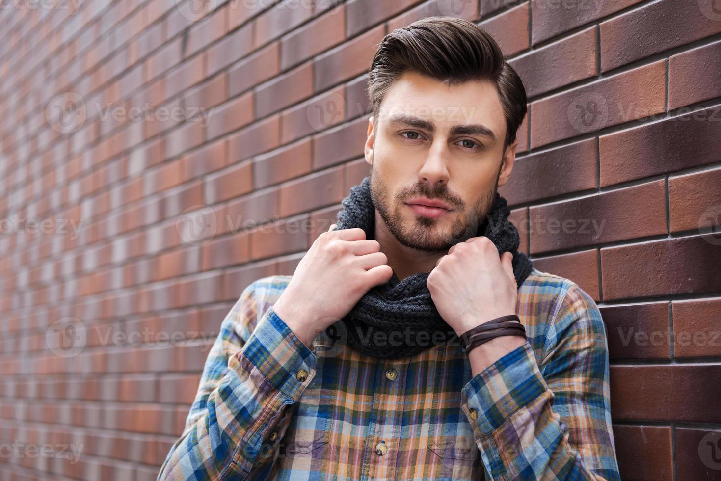 In his own style. Handsome young man leaning the wall and adjusting his ...