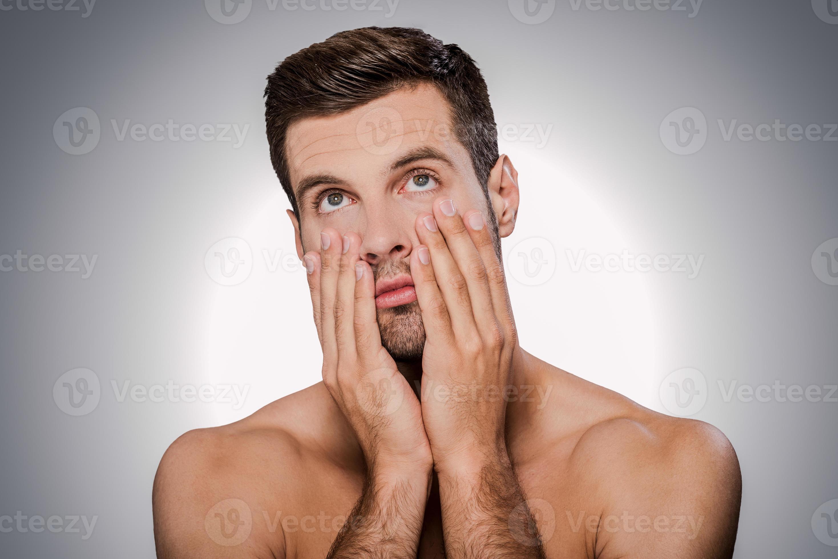 Feeling so bored. Portrait of bored young shirtless man covering mouth ...