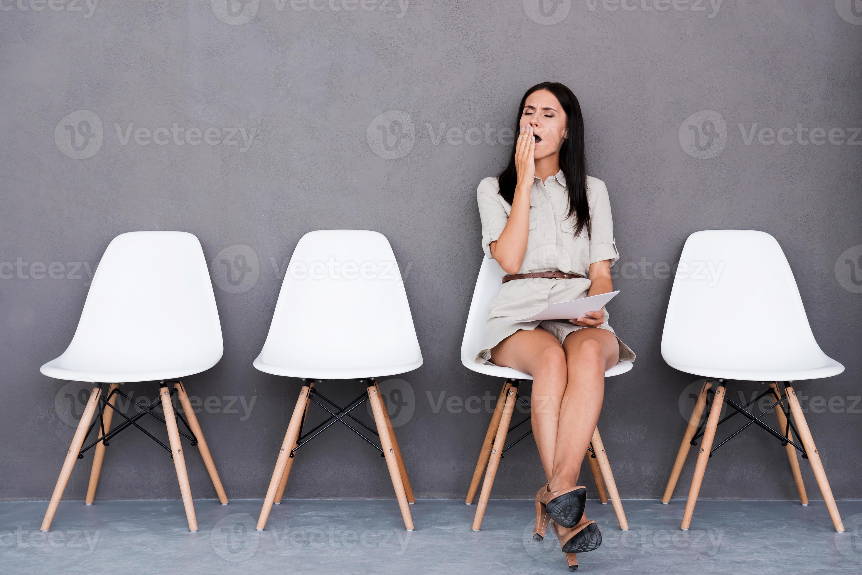 Bored of waiting. Bored young businesswoman holding paper and looking ...