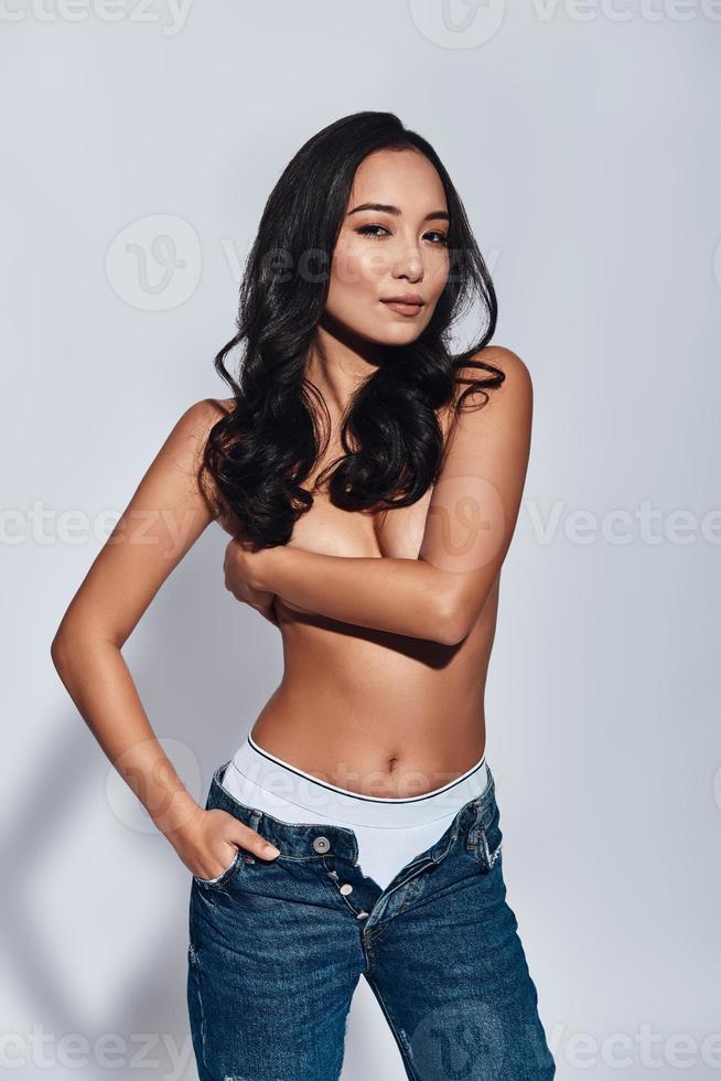 Made To Be A Model Beautiful Young Woman Smiling And Covering Breasts With Hands While Standing