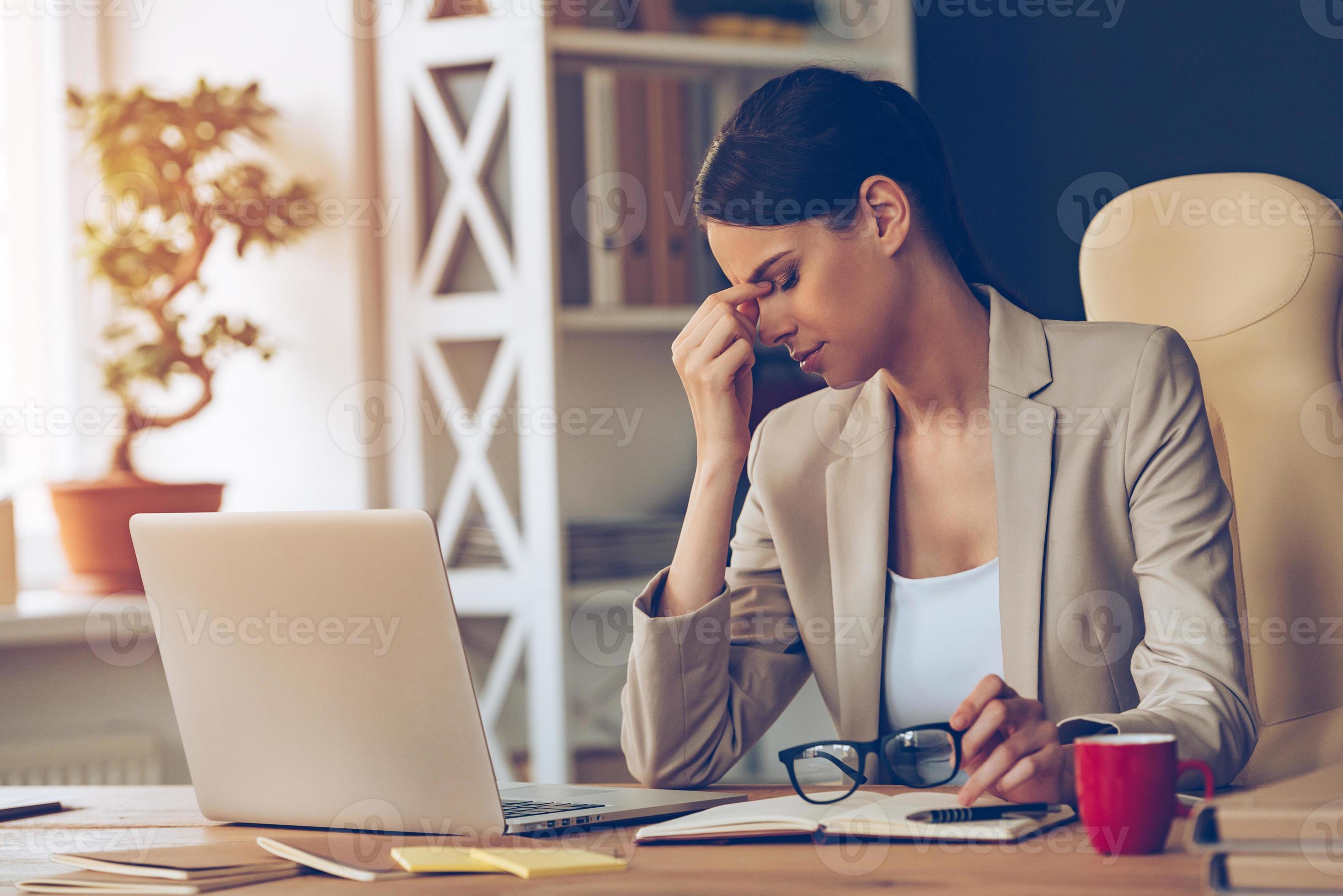 Feeling overworked. Frustrated young beautiful businesswoman looking ...