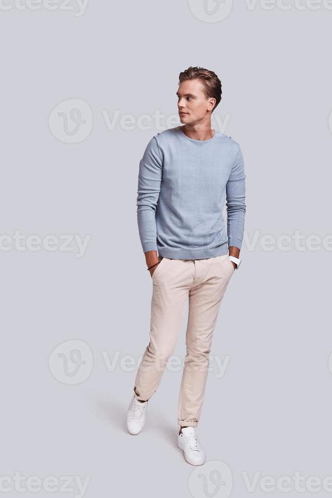 Confident young man. Full length of handsome young man looking away ...