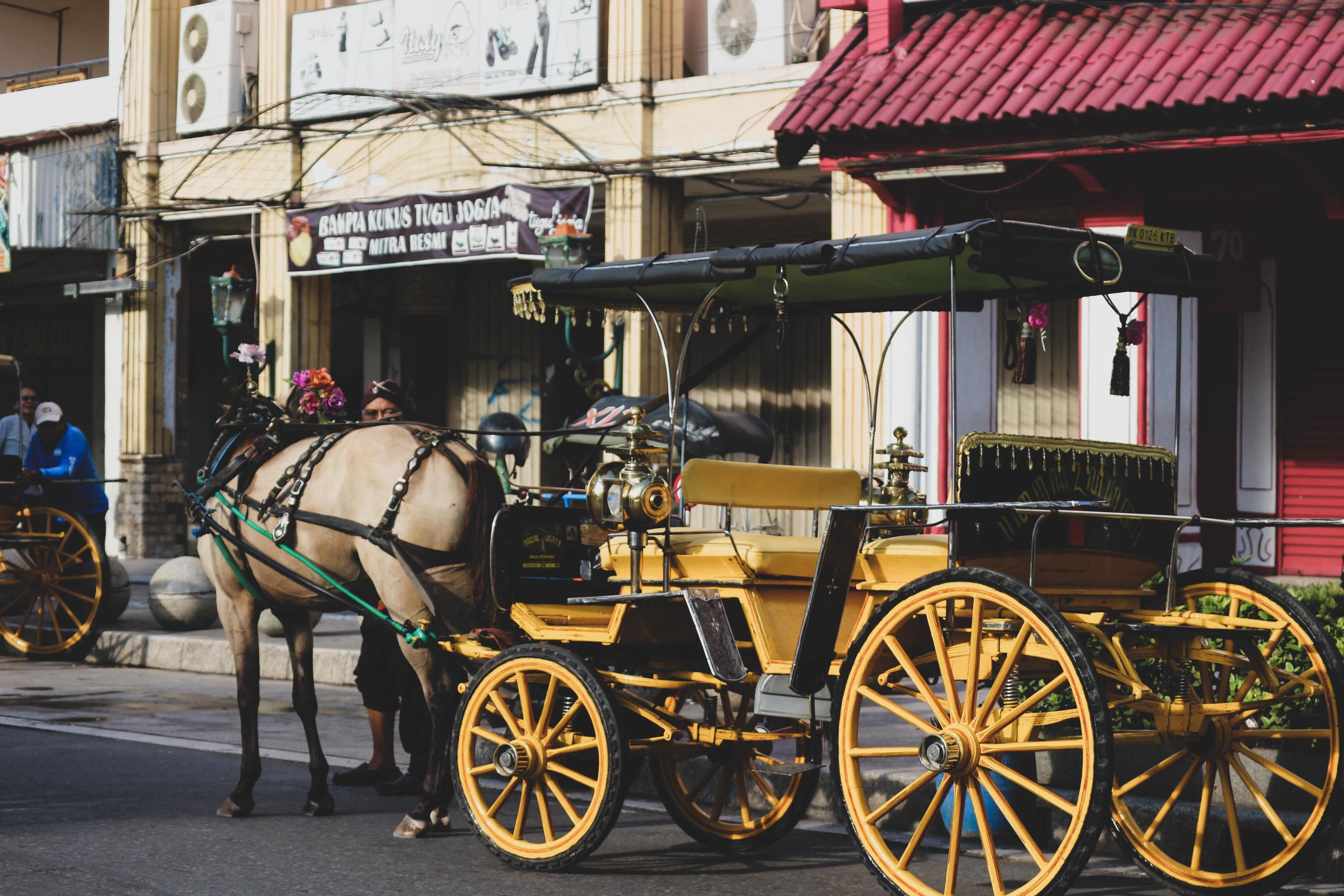Yogyakarta, Indonesia on October 23, 2022. Andong or horse-drawn carriage with its coachman ...