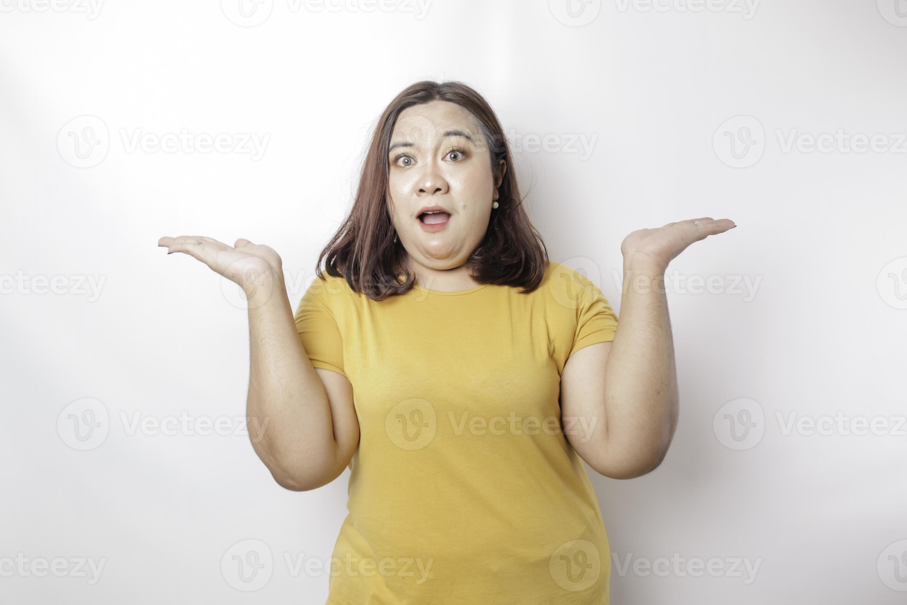 A portrait of an Asian big size woman wearing a yellow shirt shrugging ...