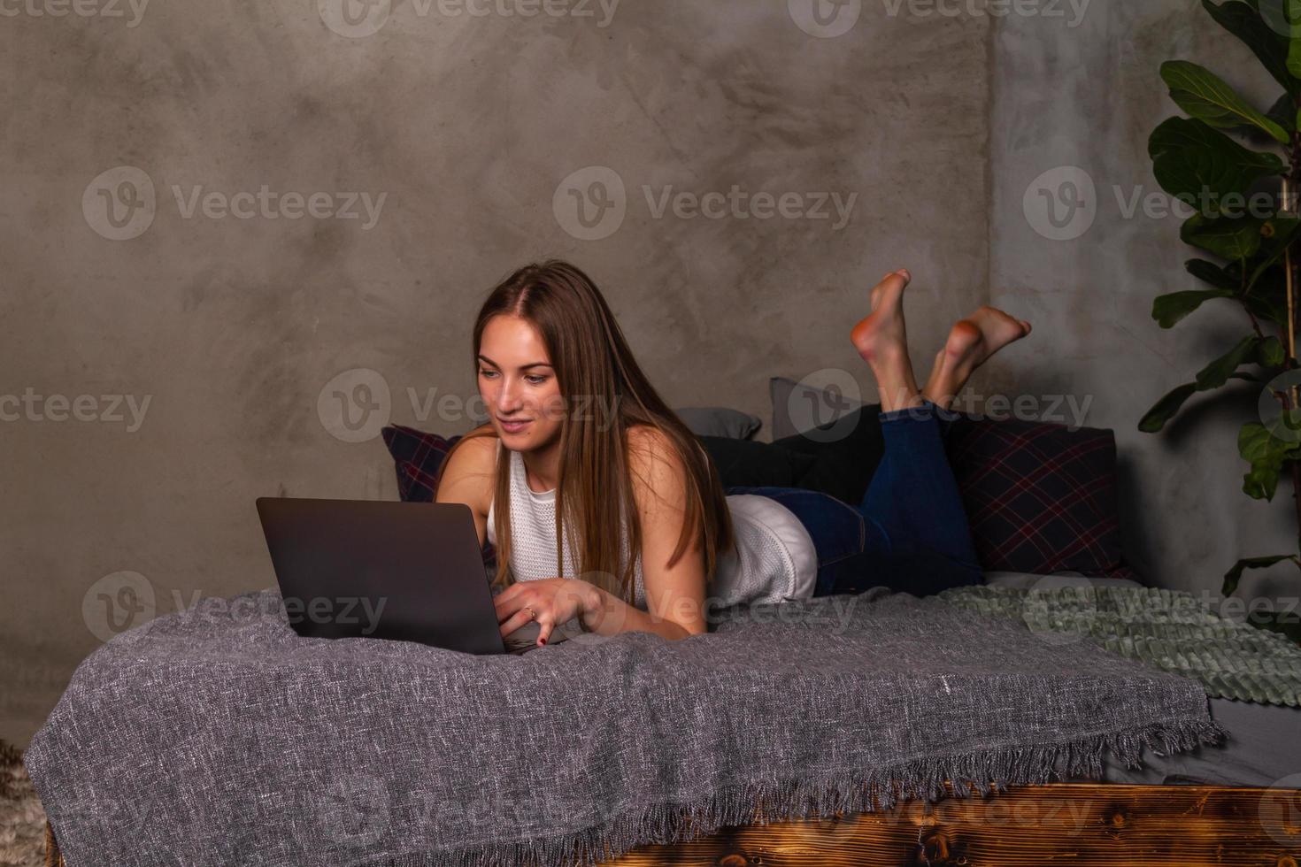 Mujer Acostada Boca Abajo En La Cama Y Trabajando En Una Computadora
