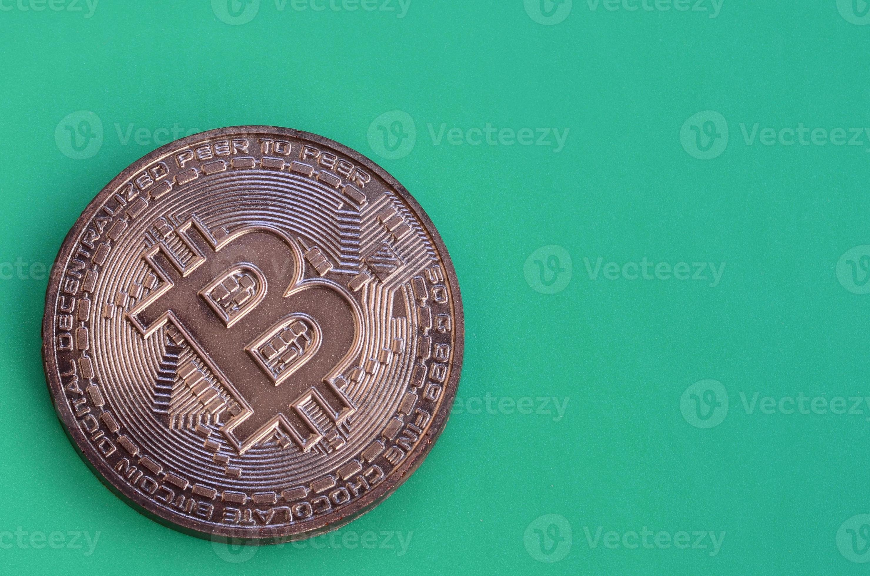 Chocolate product in the form of physical bitcoin lies on a green ... Chocolate product in the form of physical bitcoin lies on a green ...